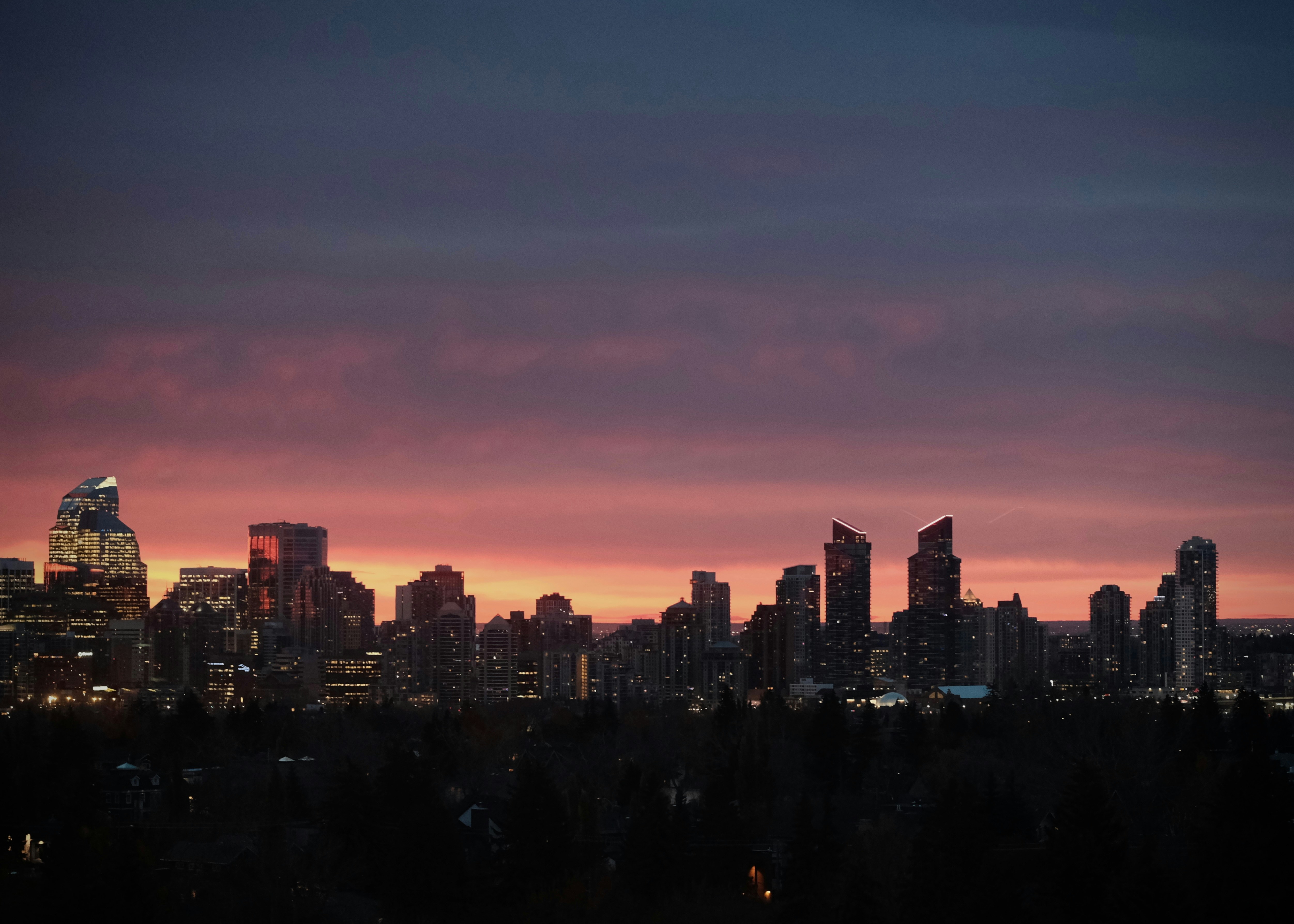 City skyline at dusk with colorful clouds