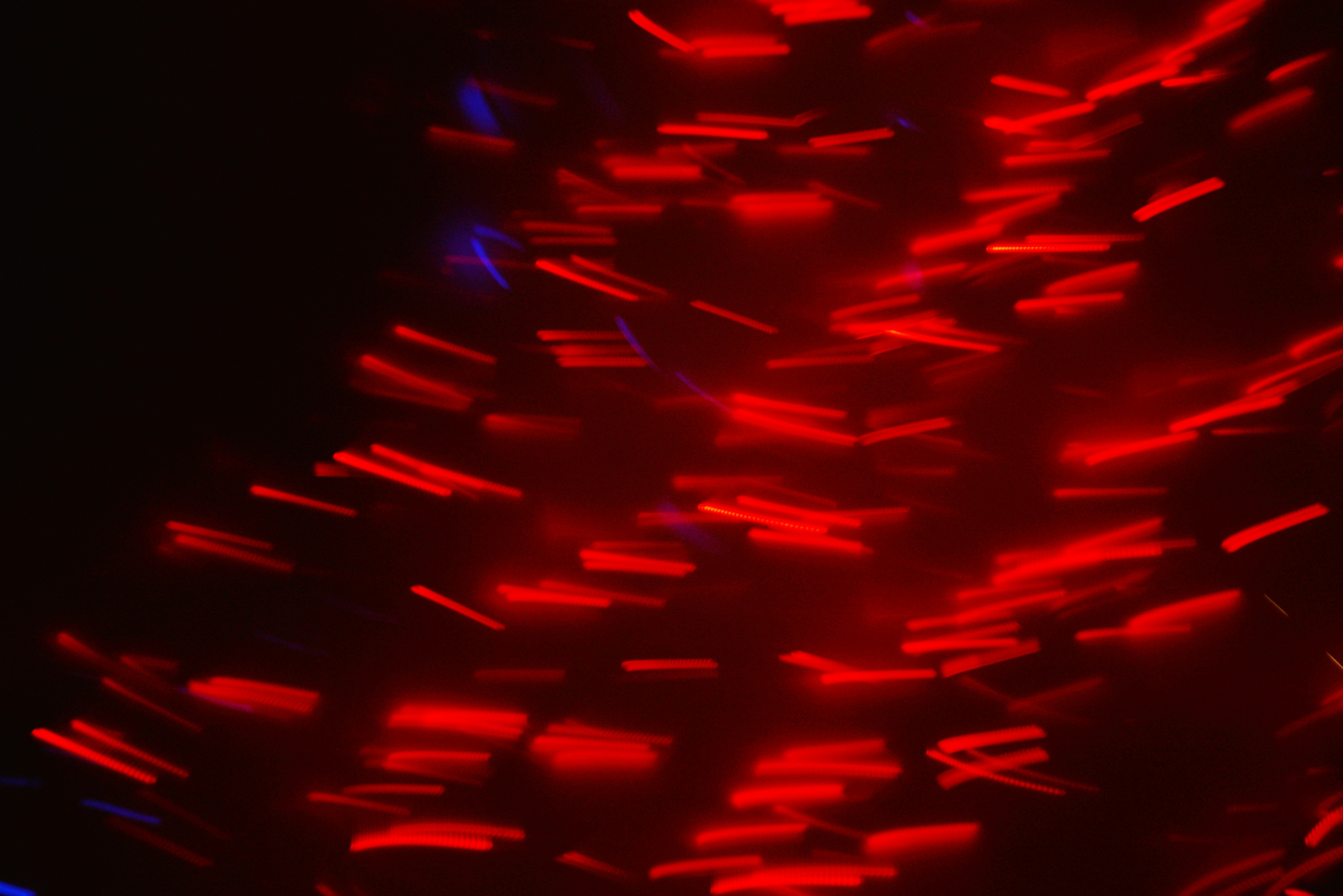 Abstract representation of red light streaks against a dark background, evoking a sense of movement and energy.