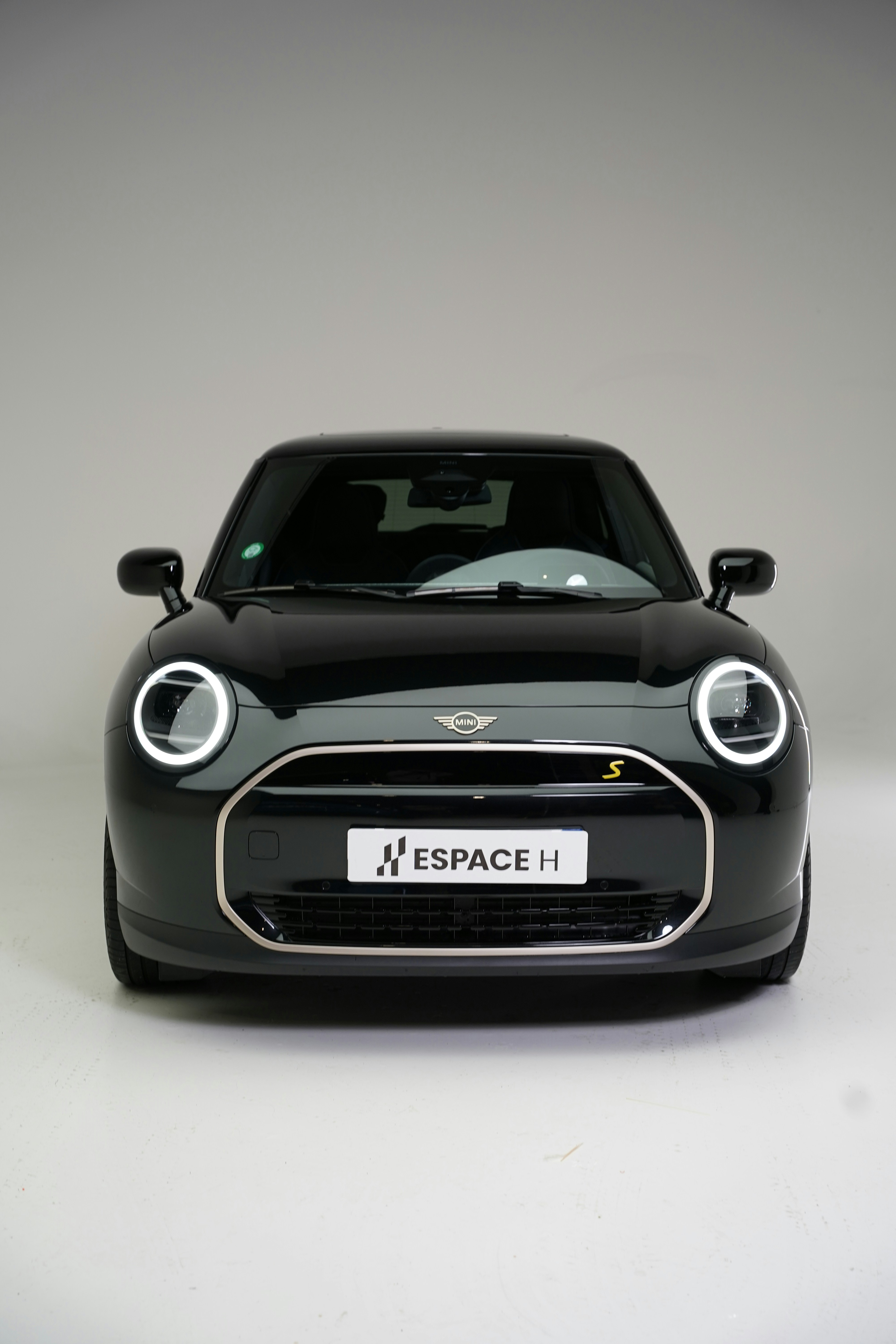 Haloed in Chrome: Front View of a Black MINI Cooper in Studio Lighting