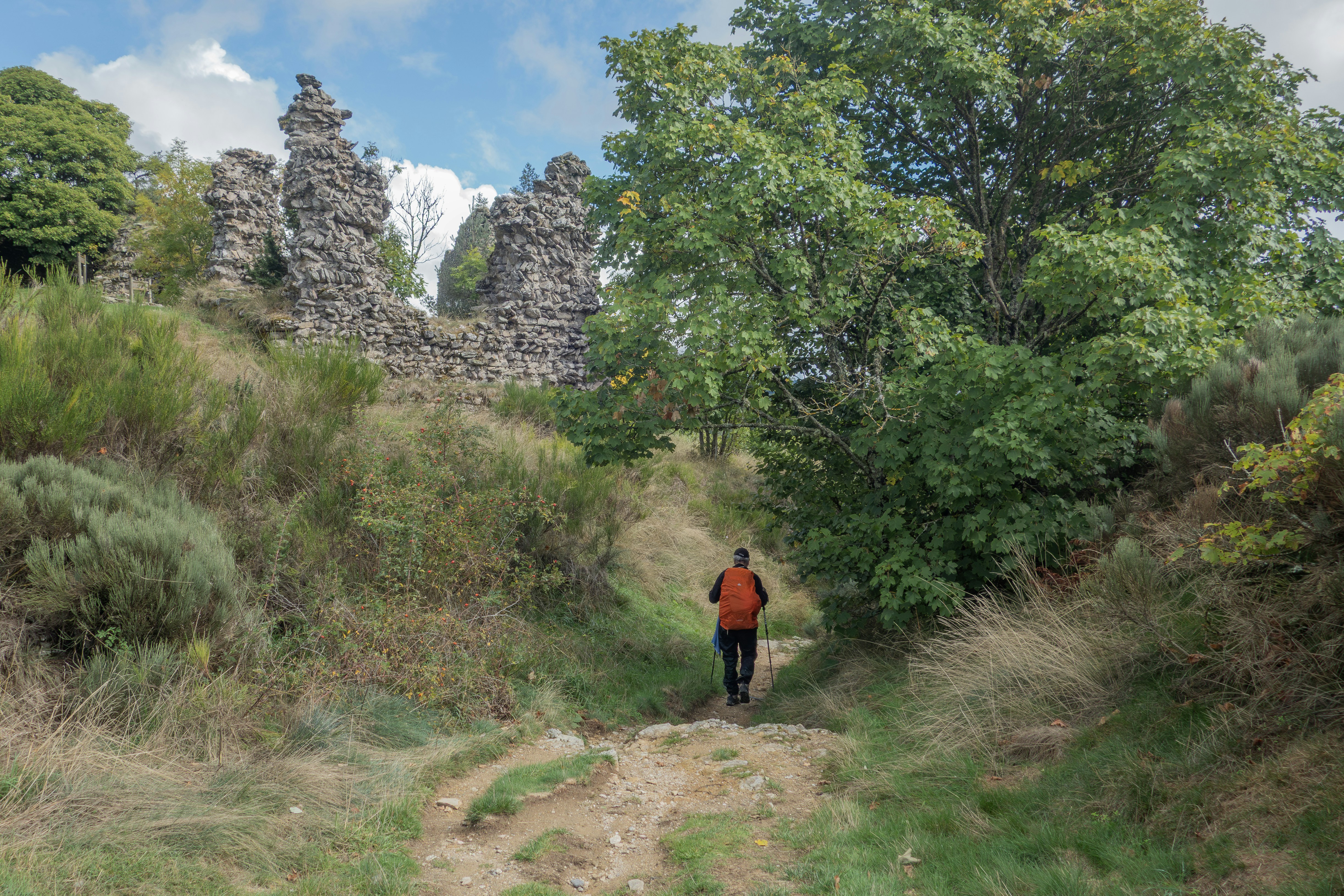 Orange Beacon on a Rural Path Toward Crumbling Pillars