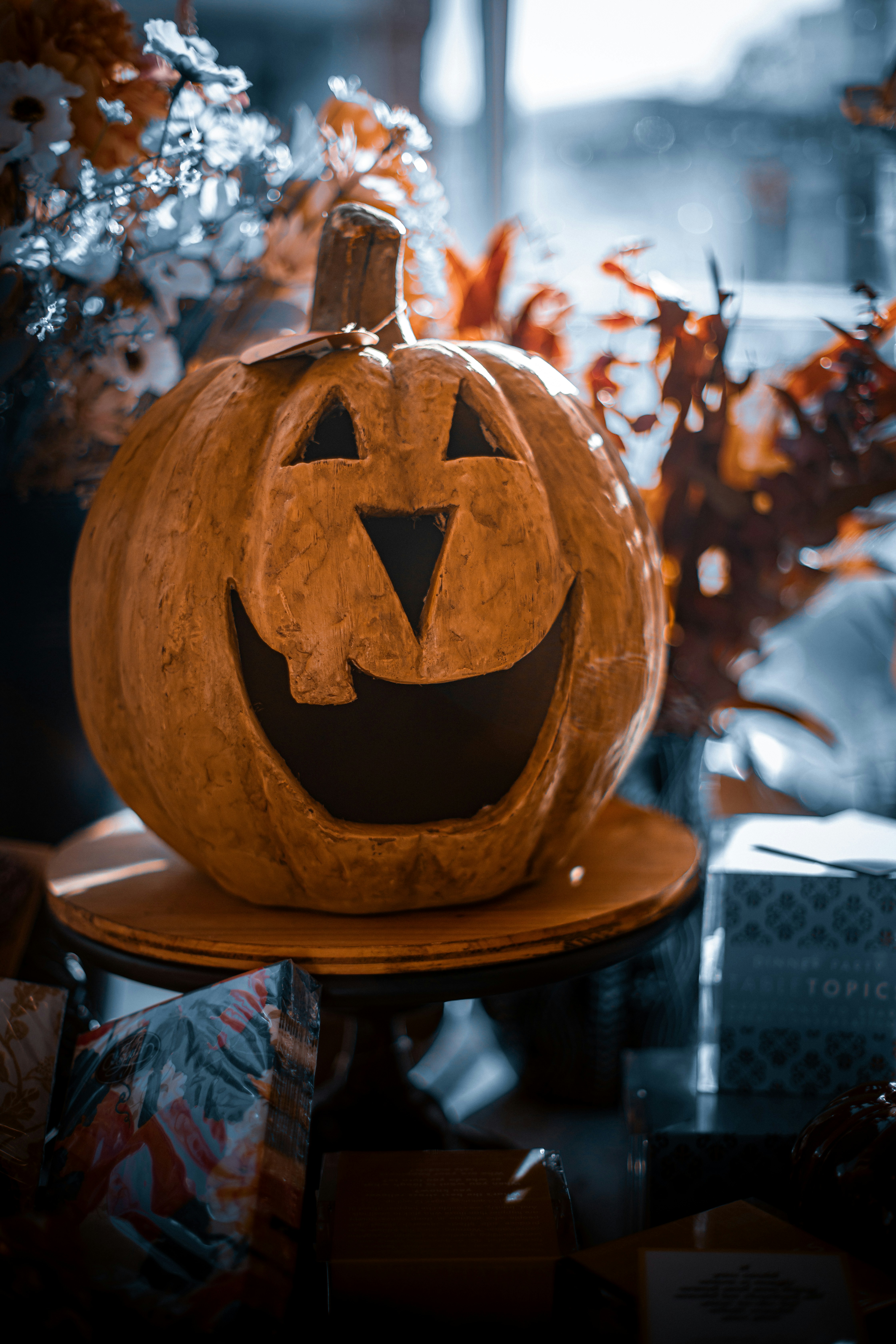 Cheerful carved pumpkin grinning amidst autumn decor, capturing the spirit of the season.