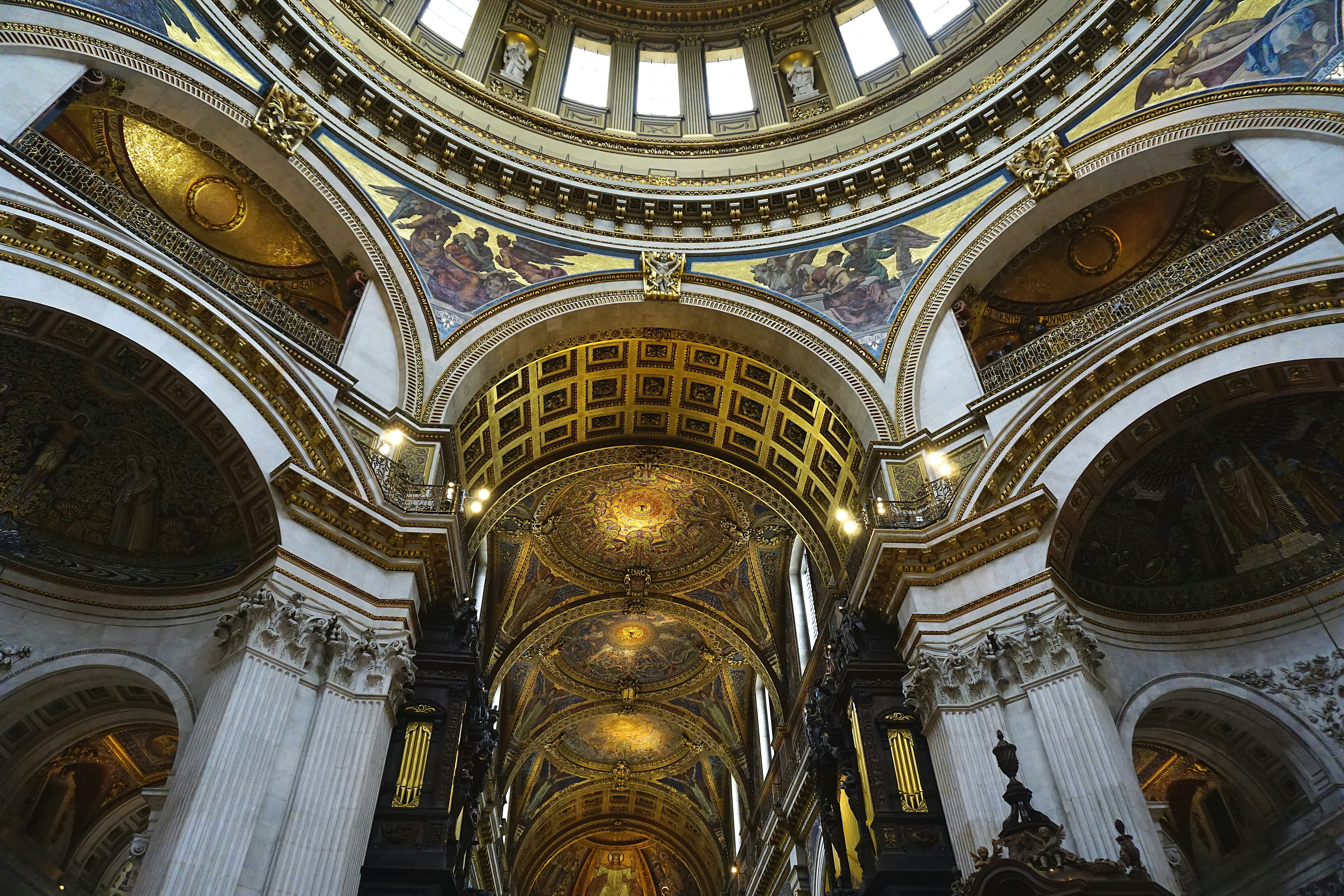 Intricate frescoes and gilded arches of St. Paul's Cathedral's dome create a mesmerizing view from below.