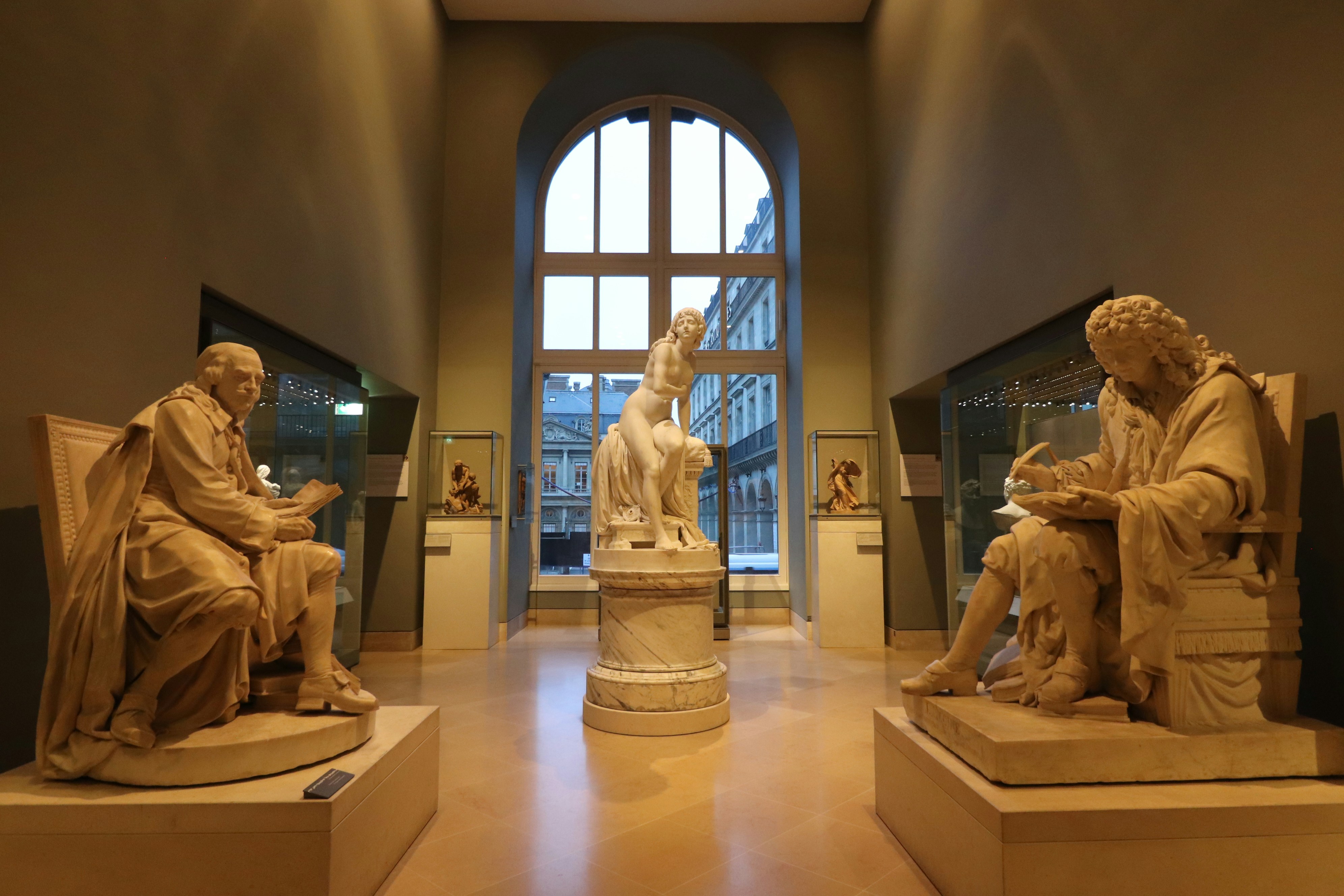 Statues in a wing of the Louvre Museum, Paris, France | Sculptures in a museum hall with large window