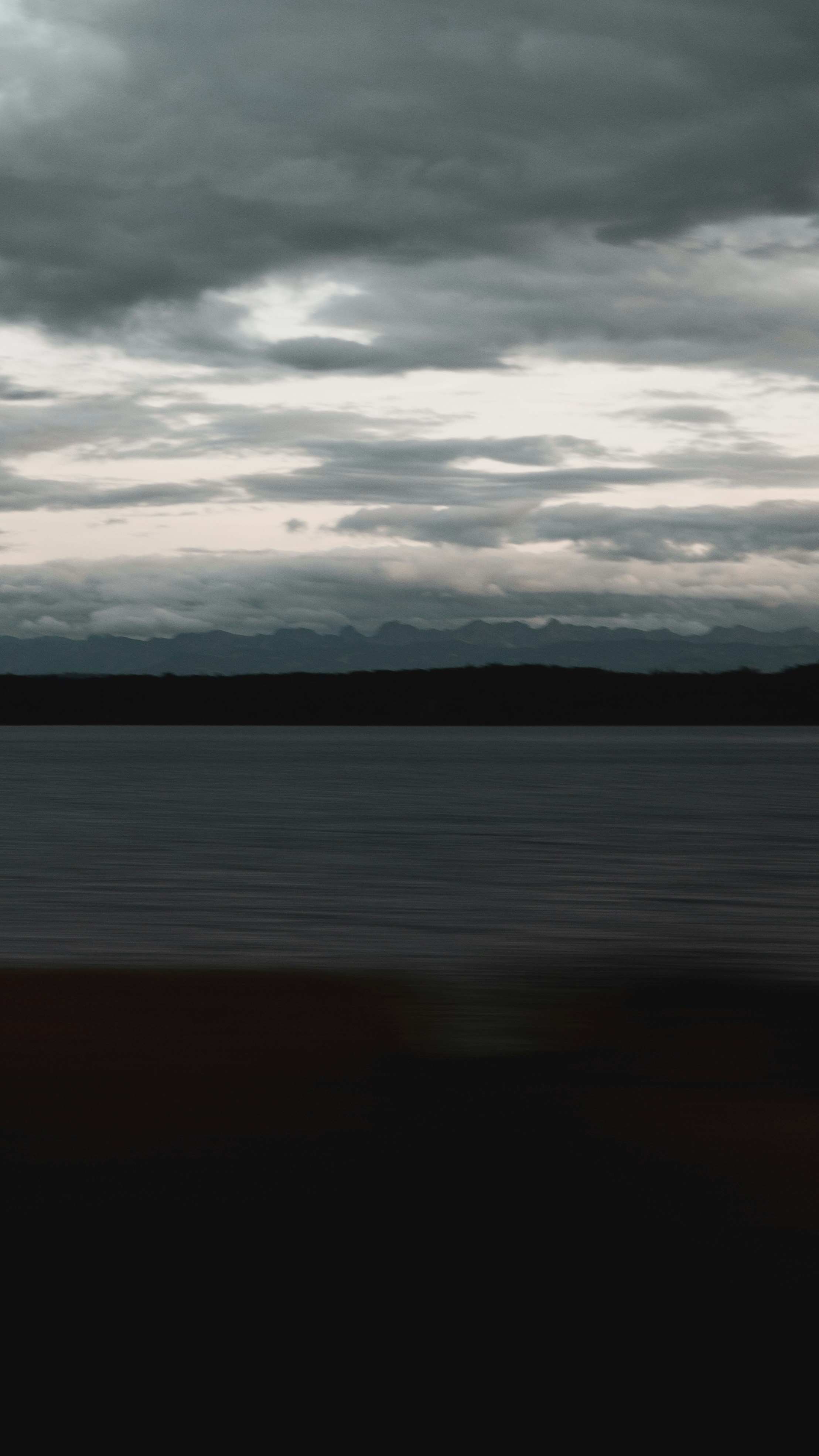 Dark clouds over a calm body of water.