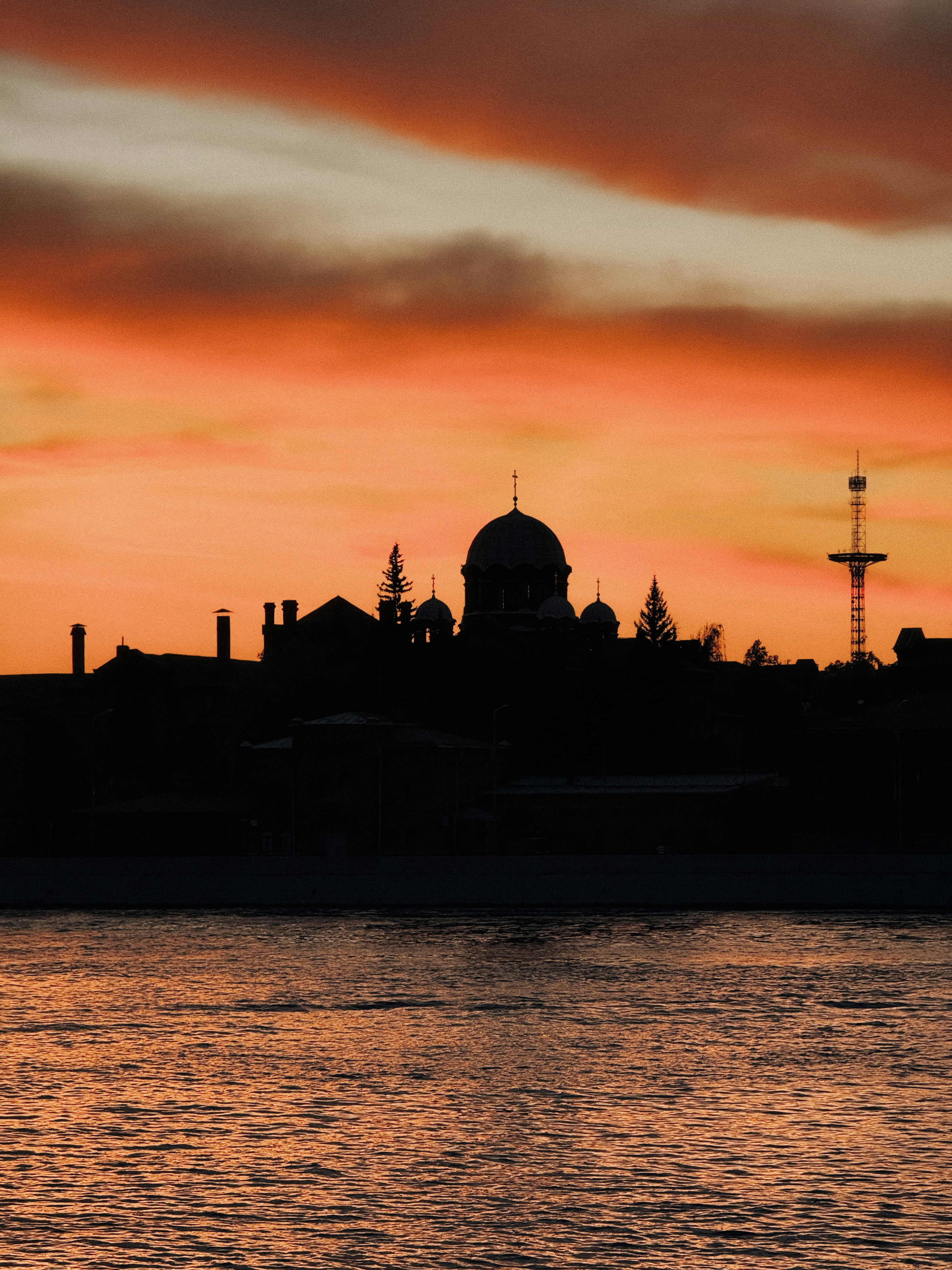 Silhouette of buildings against a vibrant sunset sky.