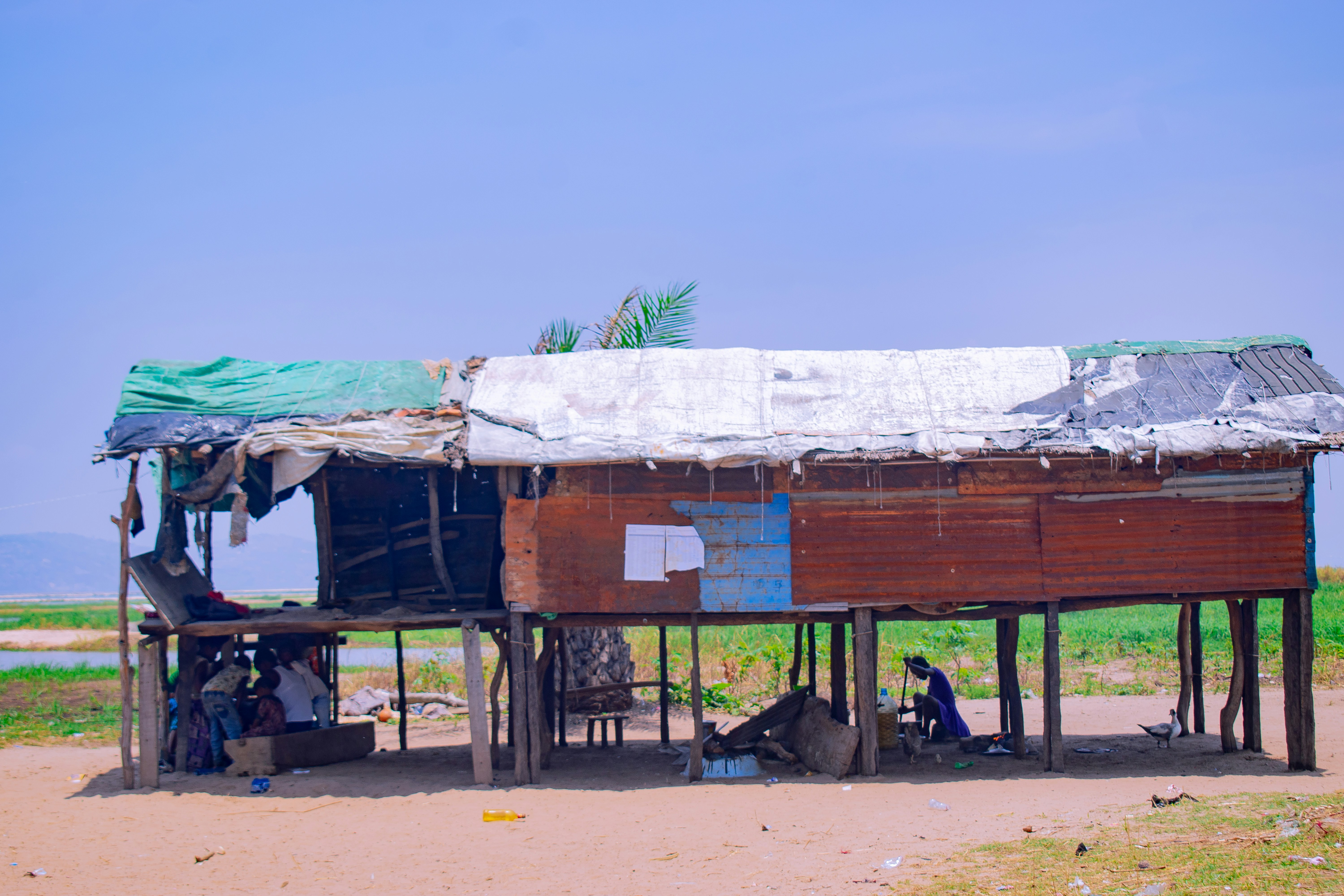 Maison de fortune, Iles Mbamou | A simple stilt house with a corrugated metal roof.
