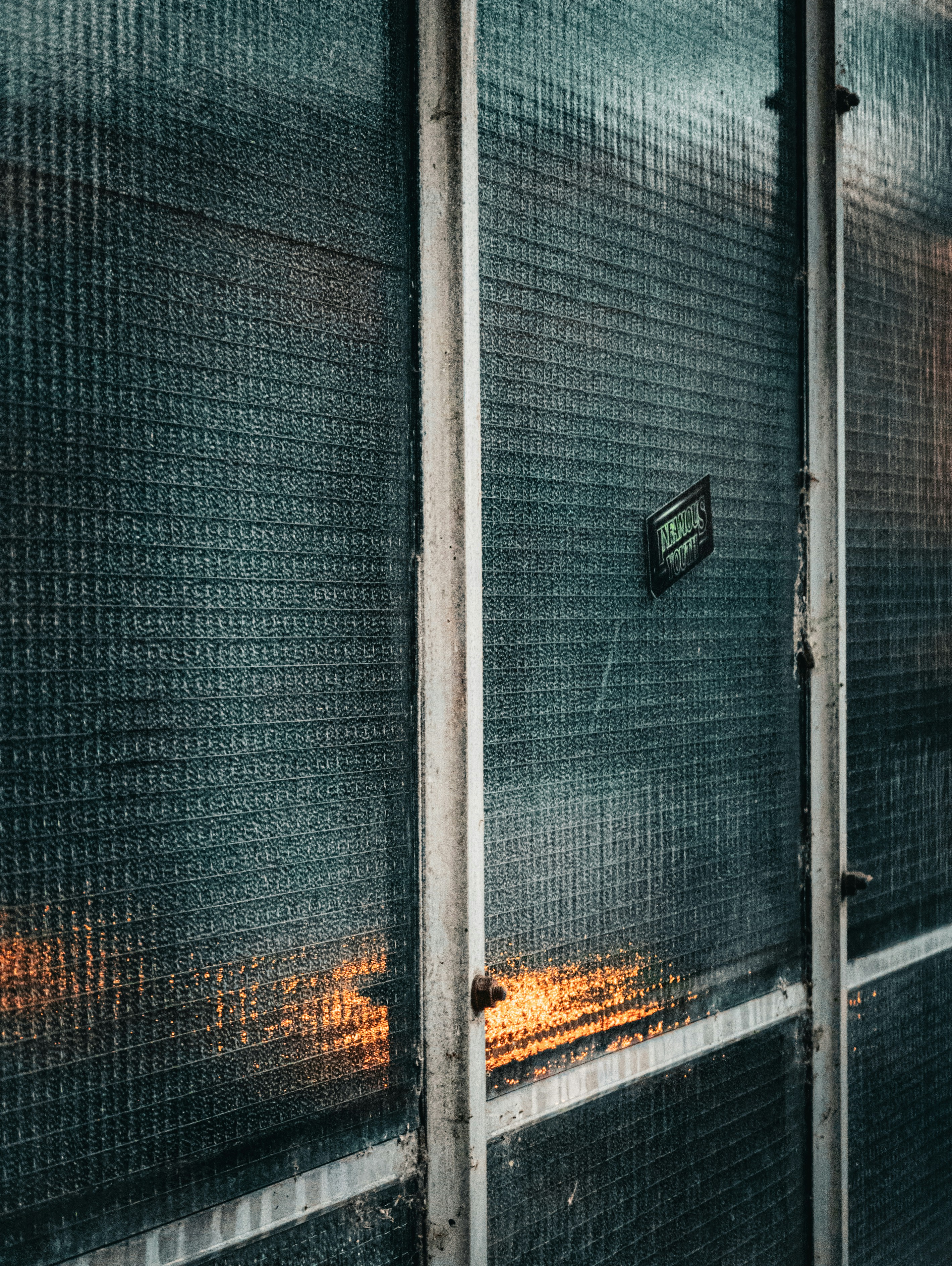 Frosted glass panels with a hint of warm light peeking through, creating an intriguing interplay of textures and shadows.