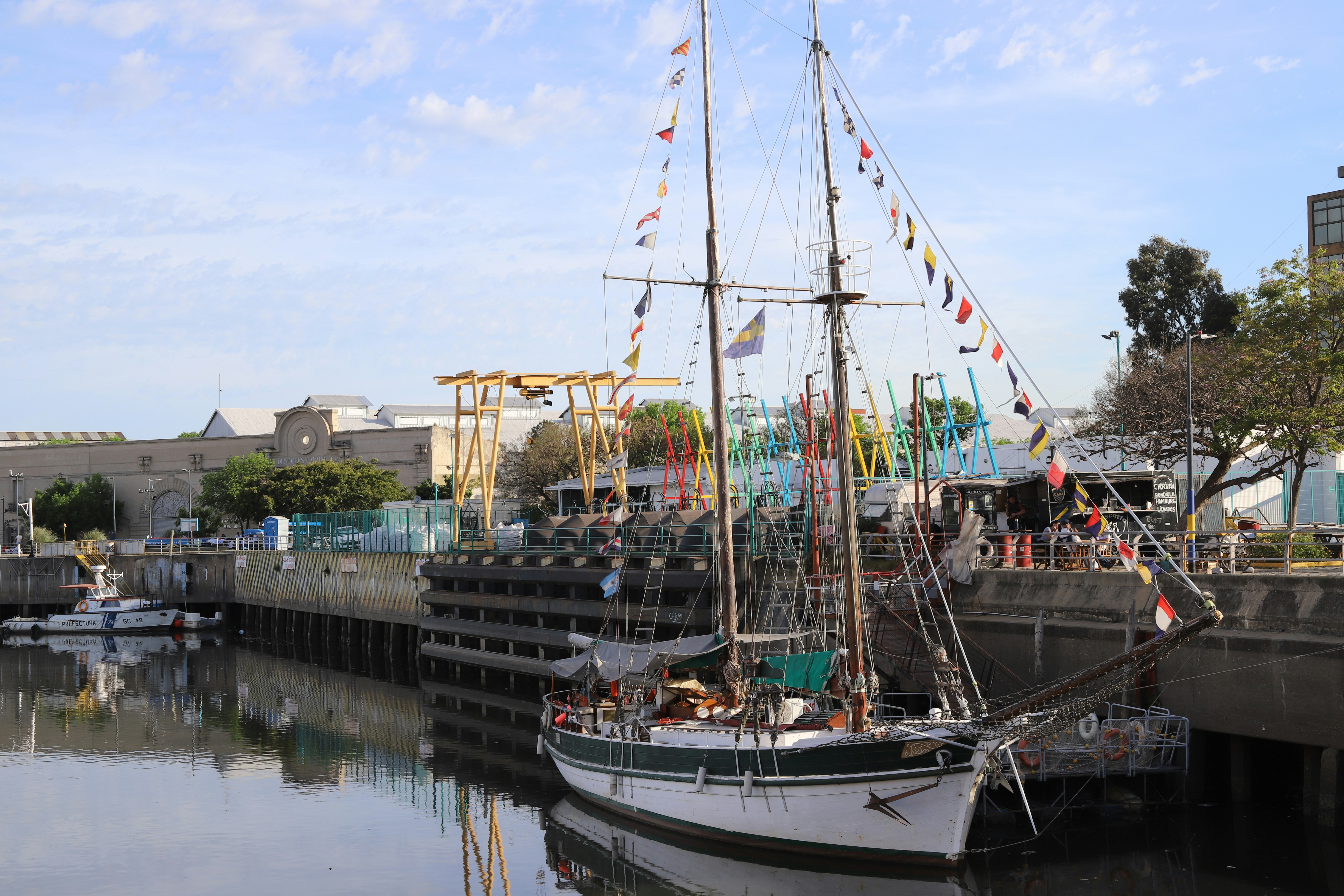 Flagged Schooner at Quiet Harbor: Rigging, Reflections, and Calm Waterfront