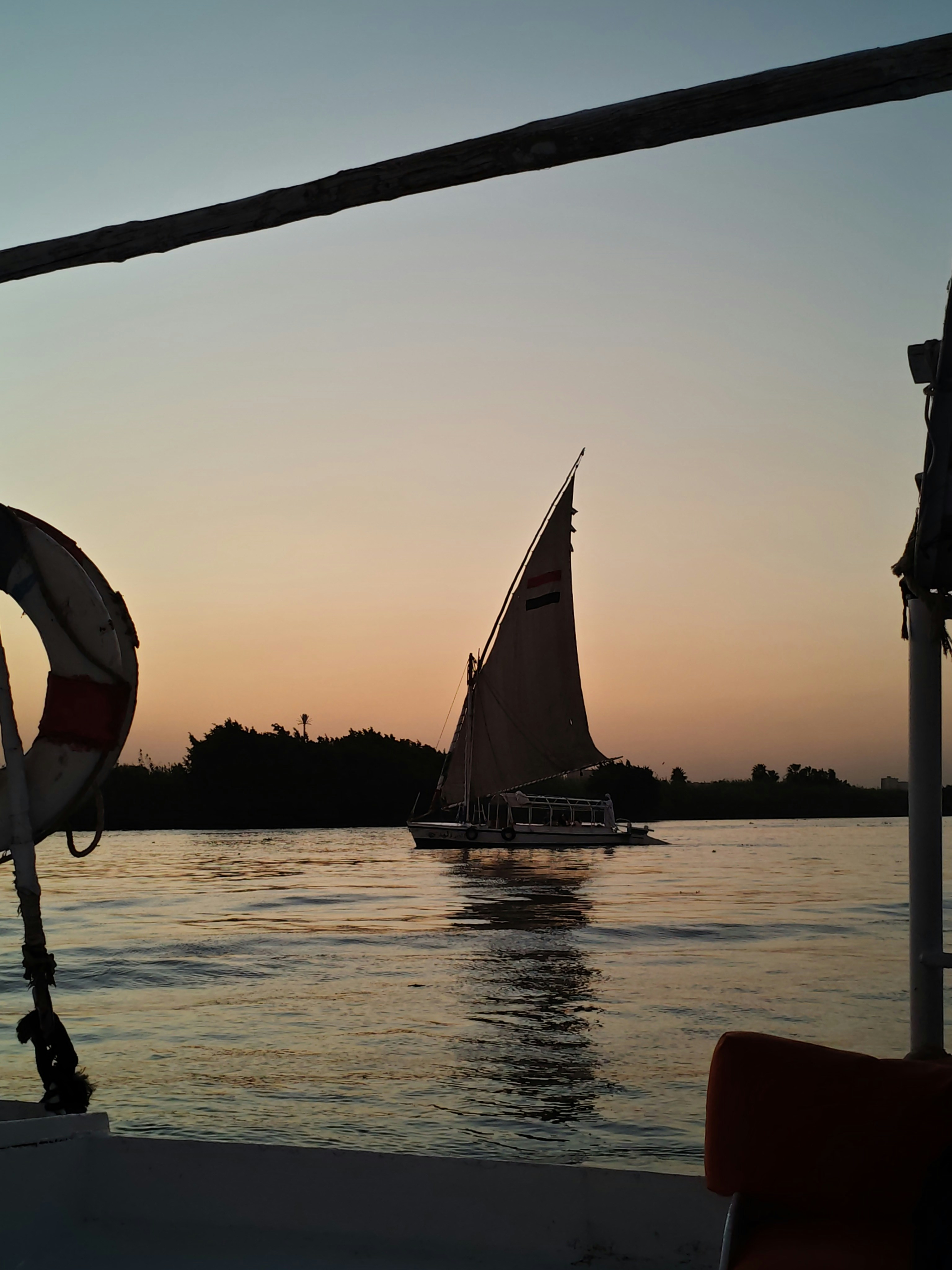 Sailboat on river at sunset