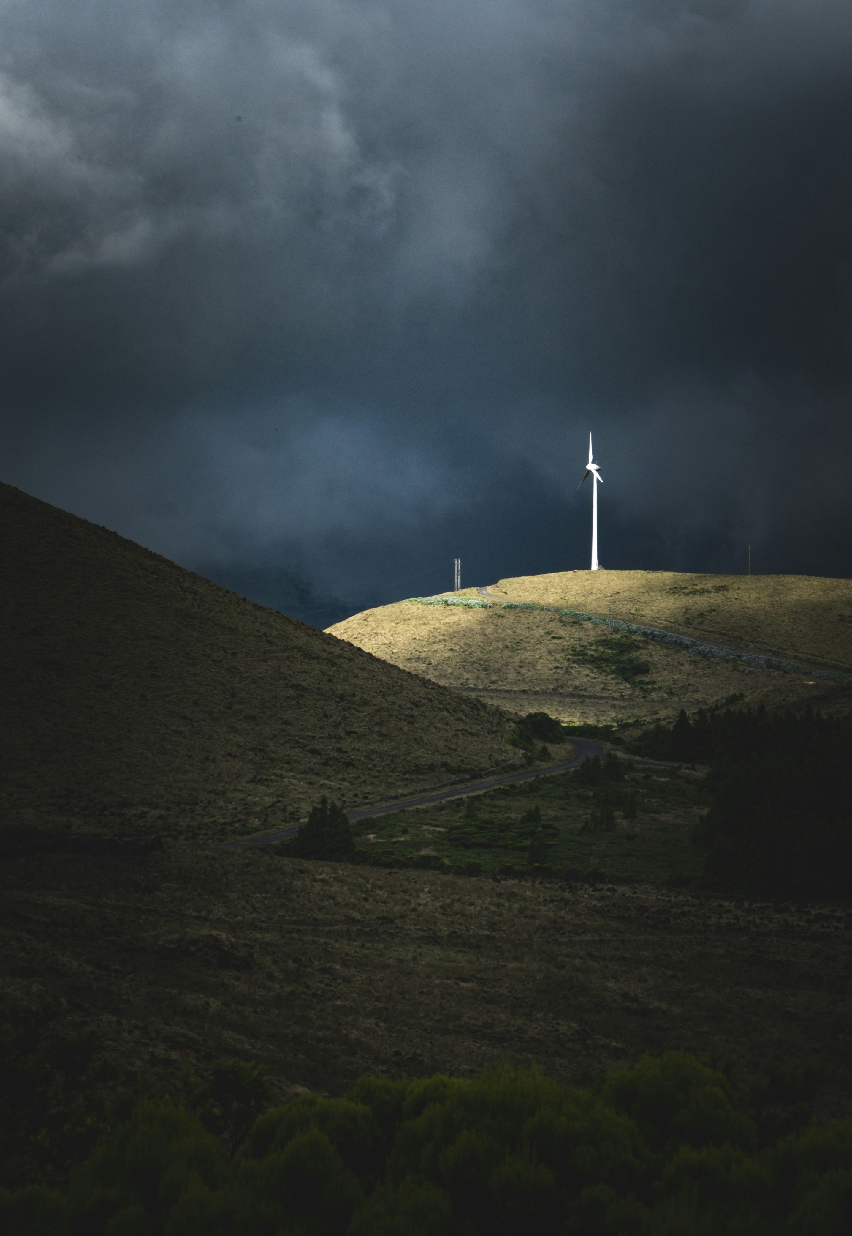 Wind turbine on a hill under stormy skies