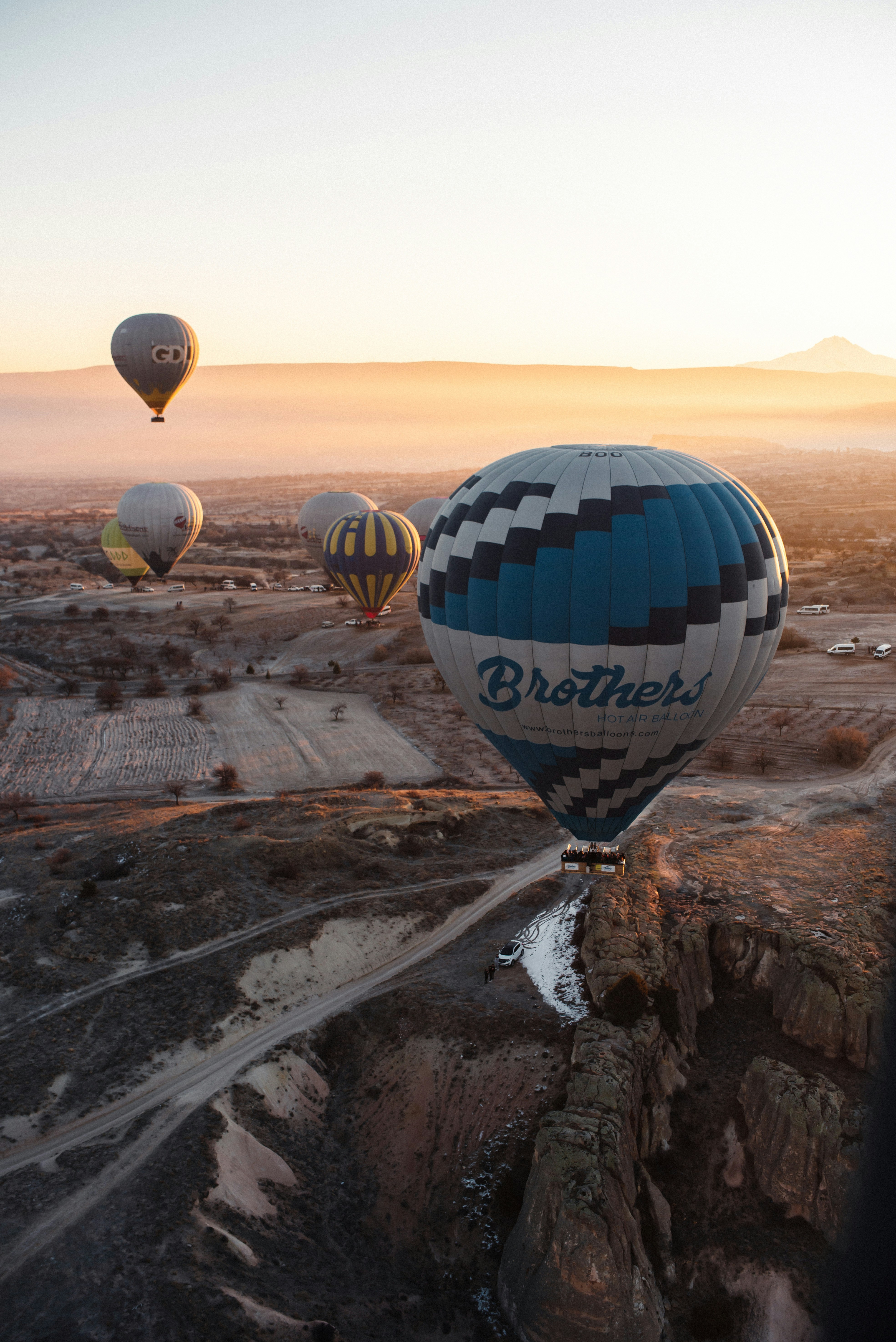 Hot air balloons drifting gracefully over a serene landscape at dawn, showcasing vibrant colors against a soft sunrise backdrop.