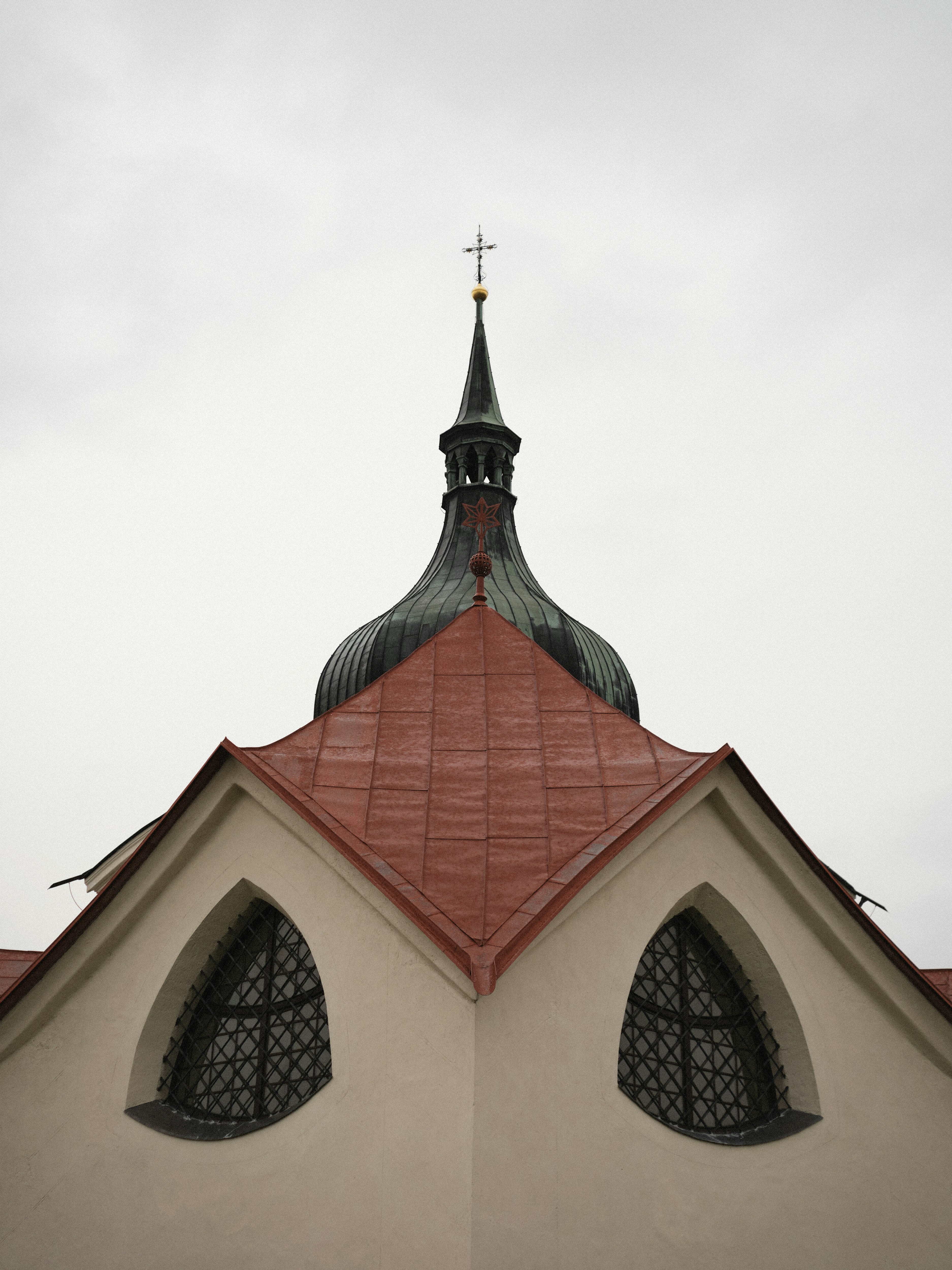 Church roof with distinctive windows and spire.