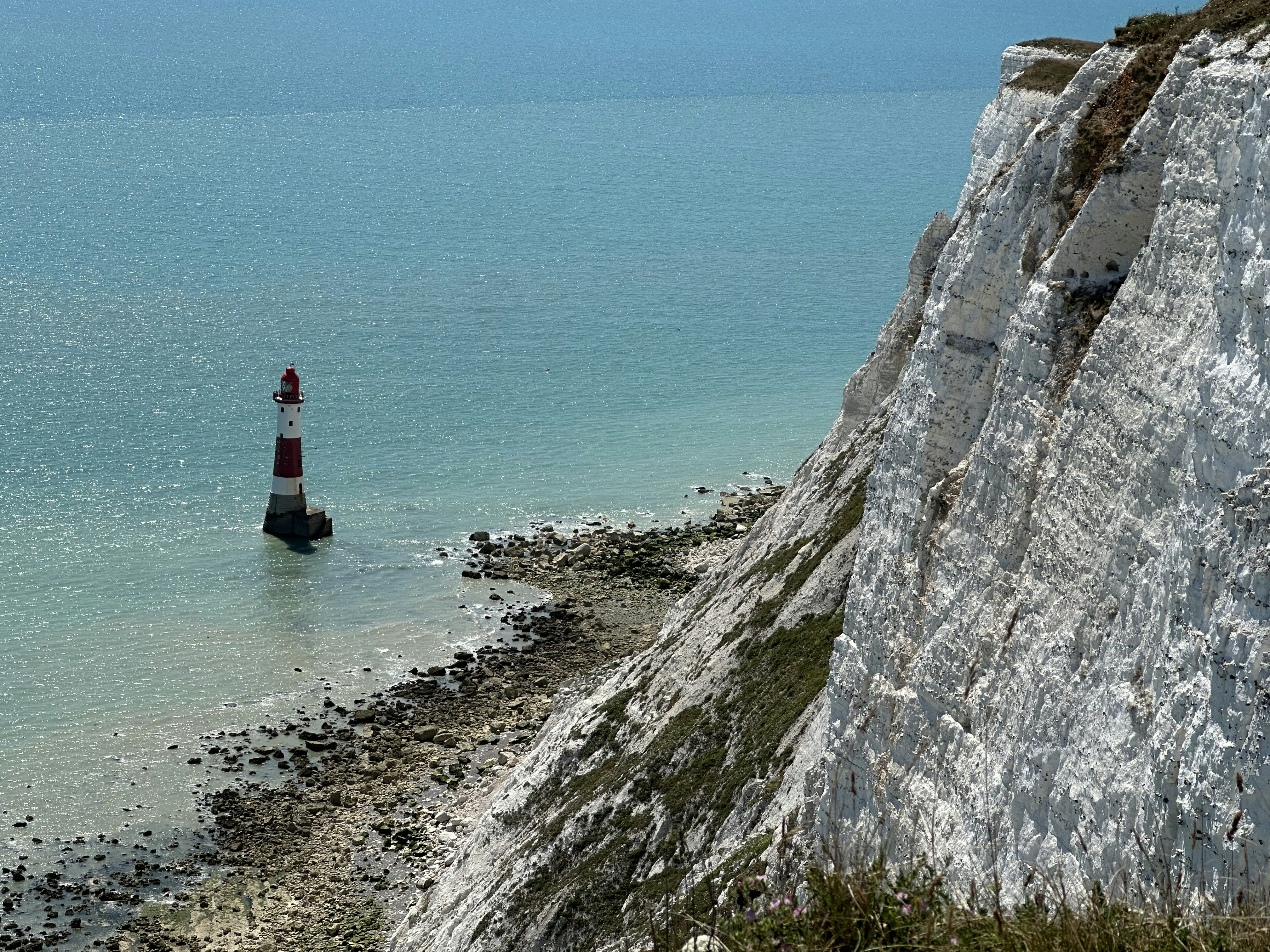Lighthouse at the Edge: Turquoise Sea Meets White Cliffs