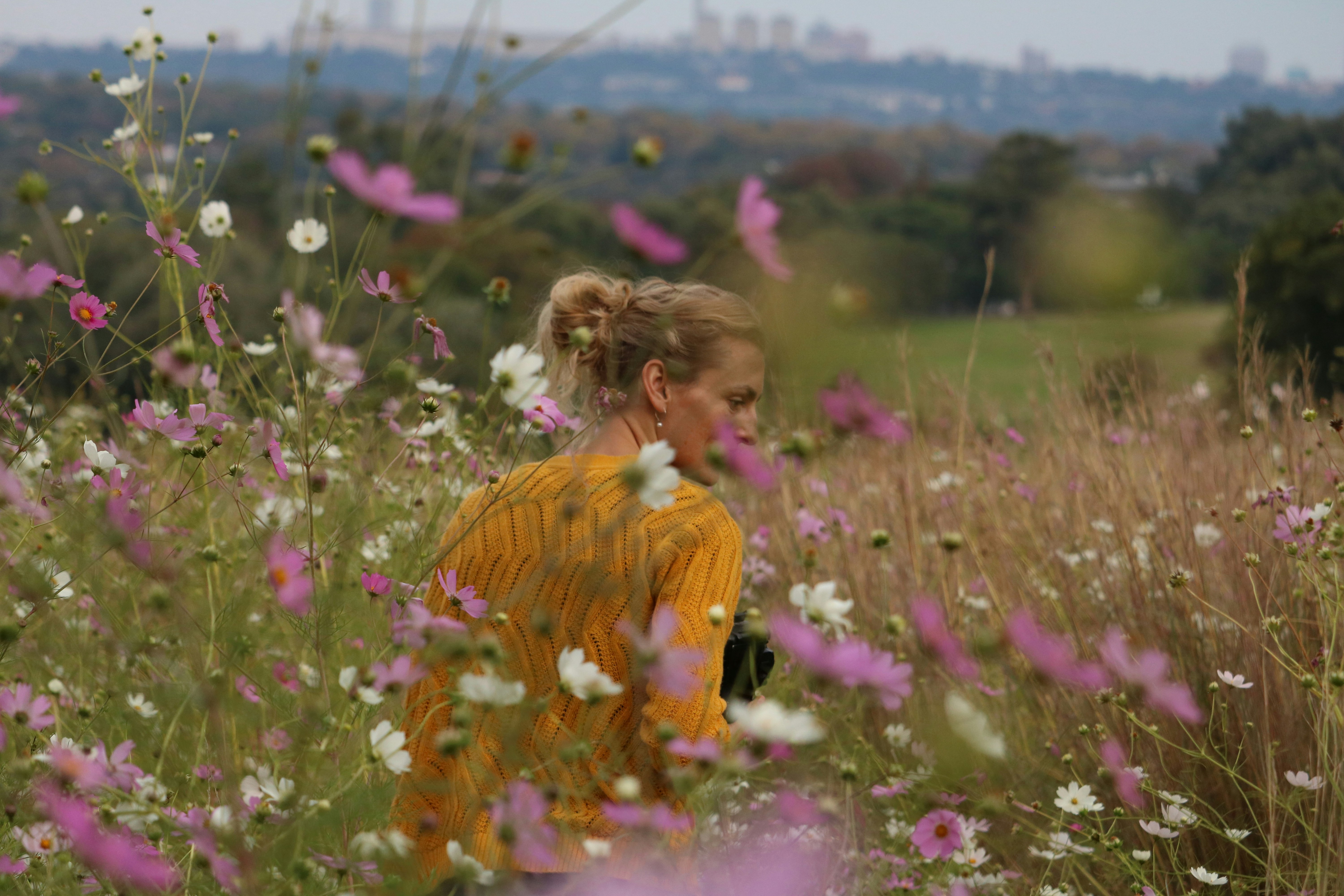 Woman walking through a field of wildflowers.