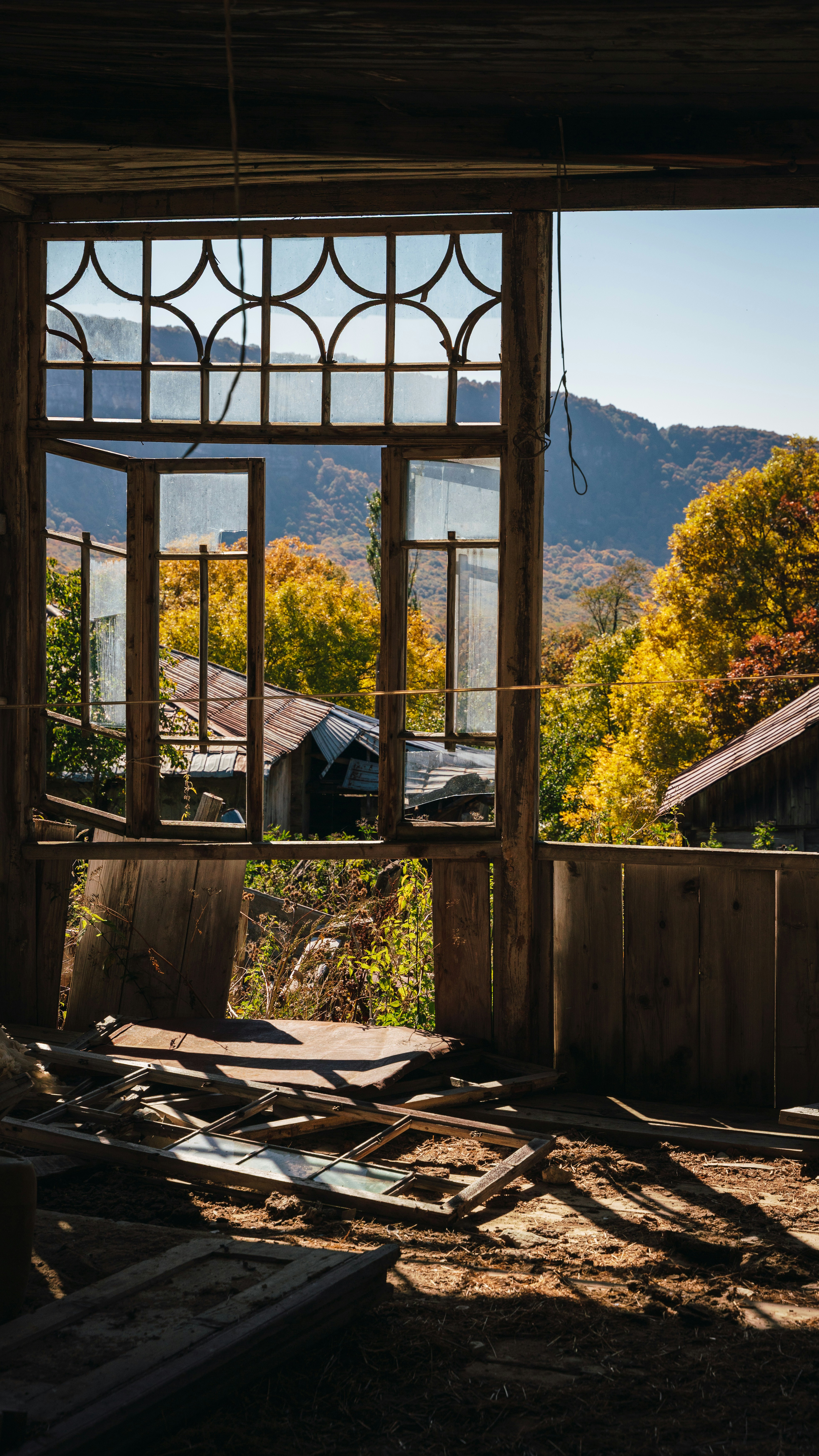 Between Decay and Distant Ridge: Light Framed by a Weathered Window