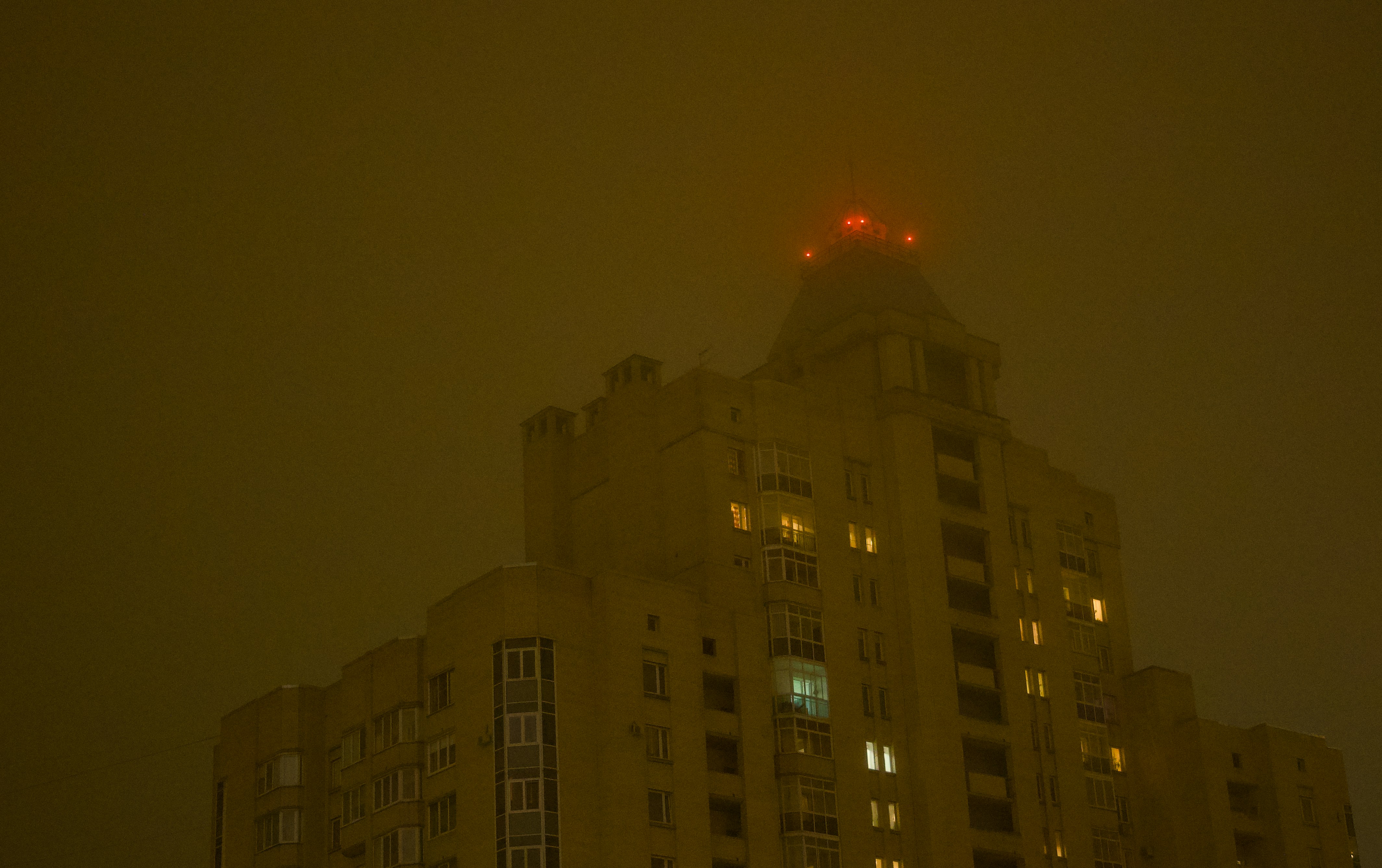 Red-tinted Summit: A Foggy High-Rrise Under Low Light