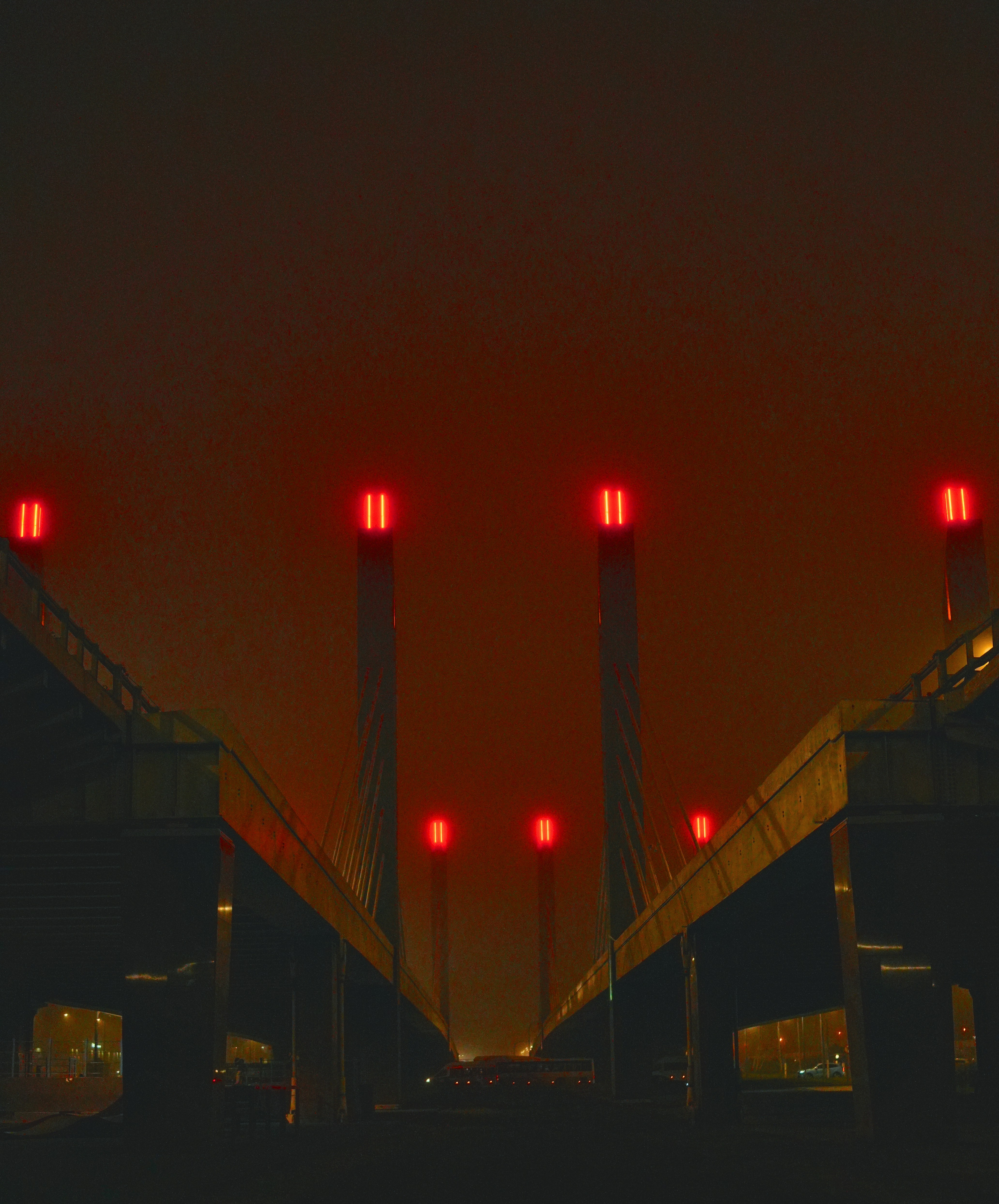Neon Sentinels: A Bridge's Vigil in the Fog
