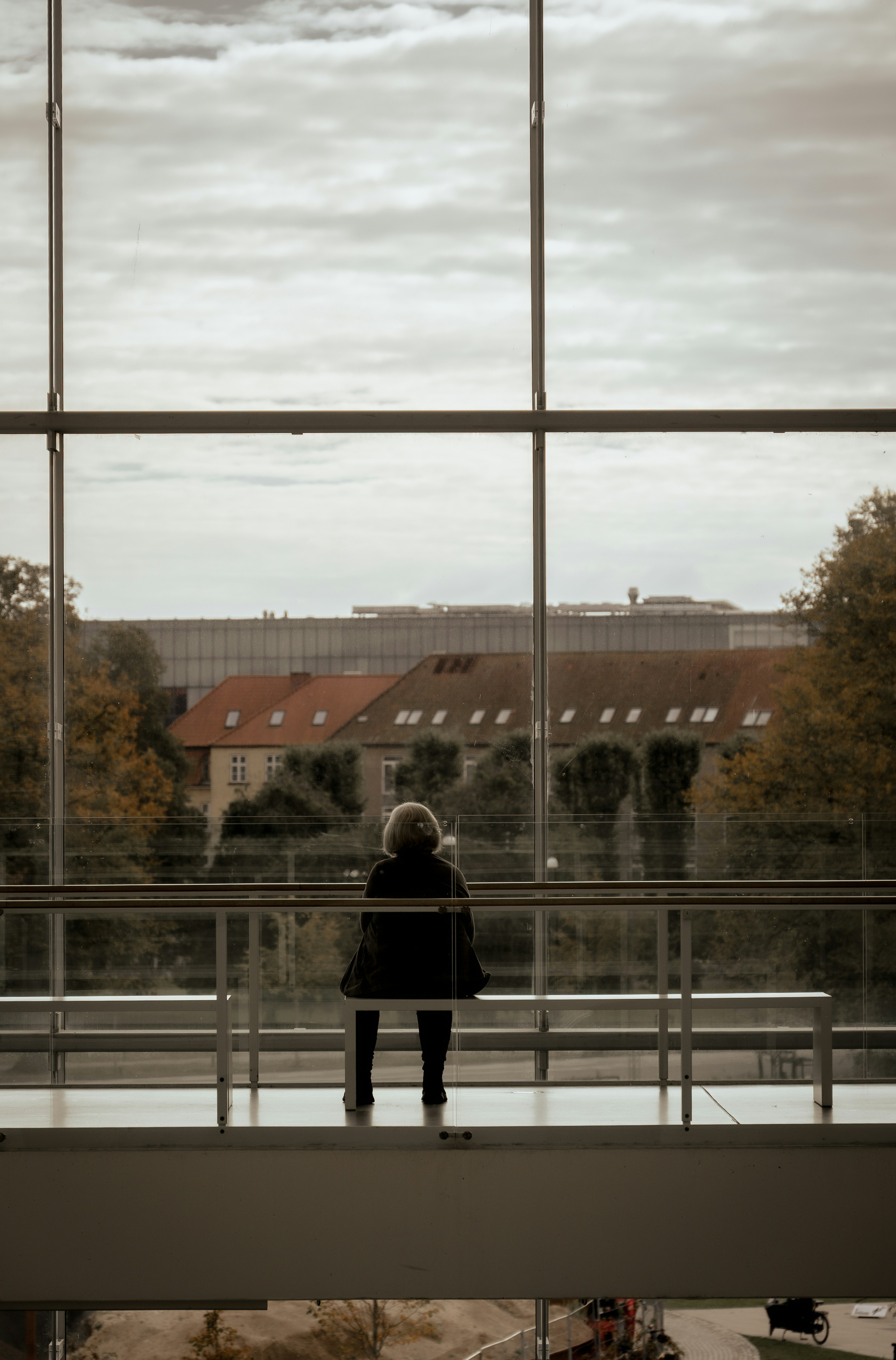 Person looking out a large window at buildings photo – Free Art Image ...