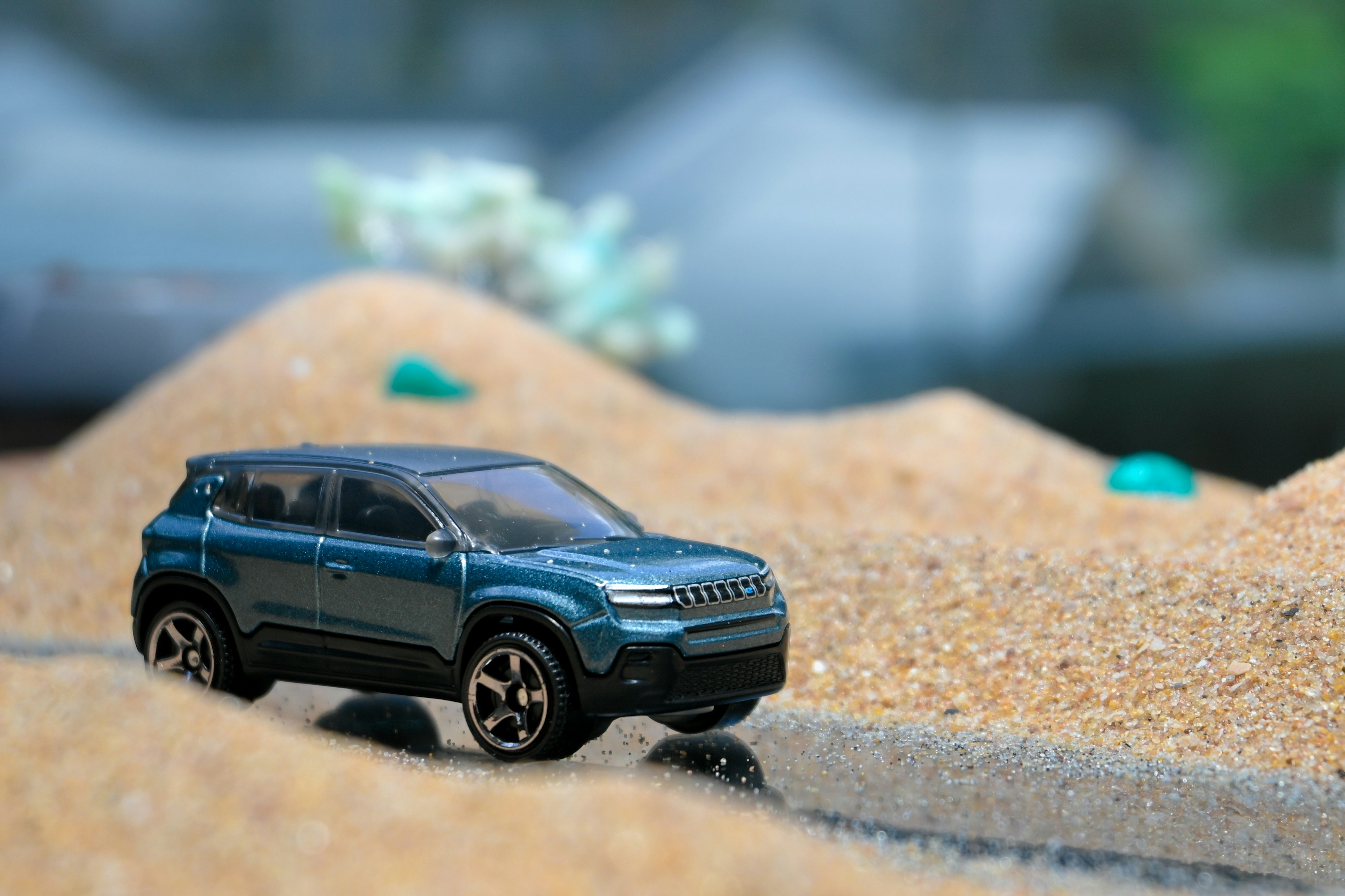 Miniature SUV on a sandy dune: a tiny journey through a gritty landscape
