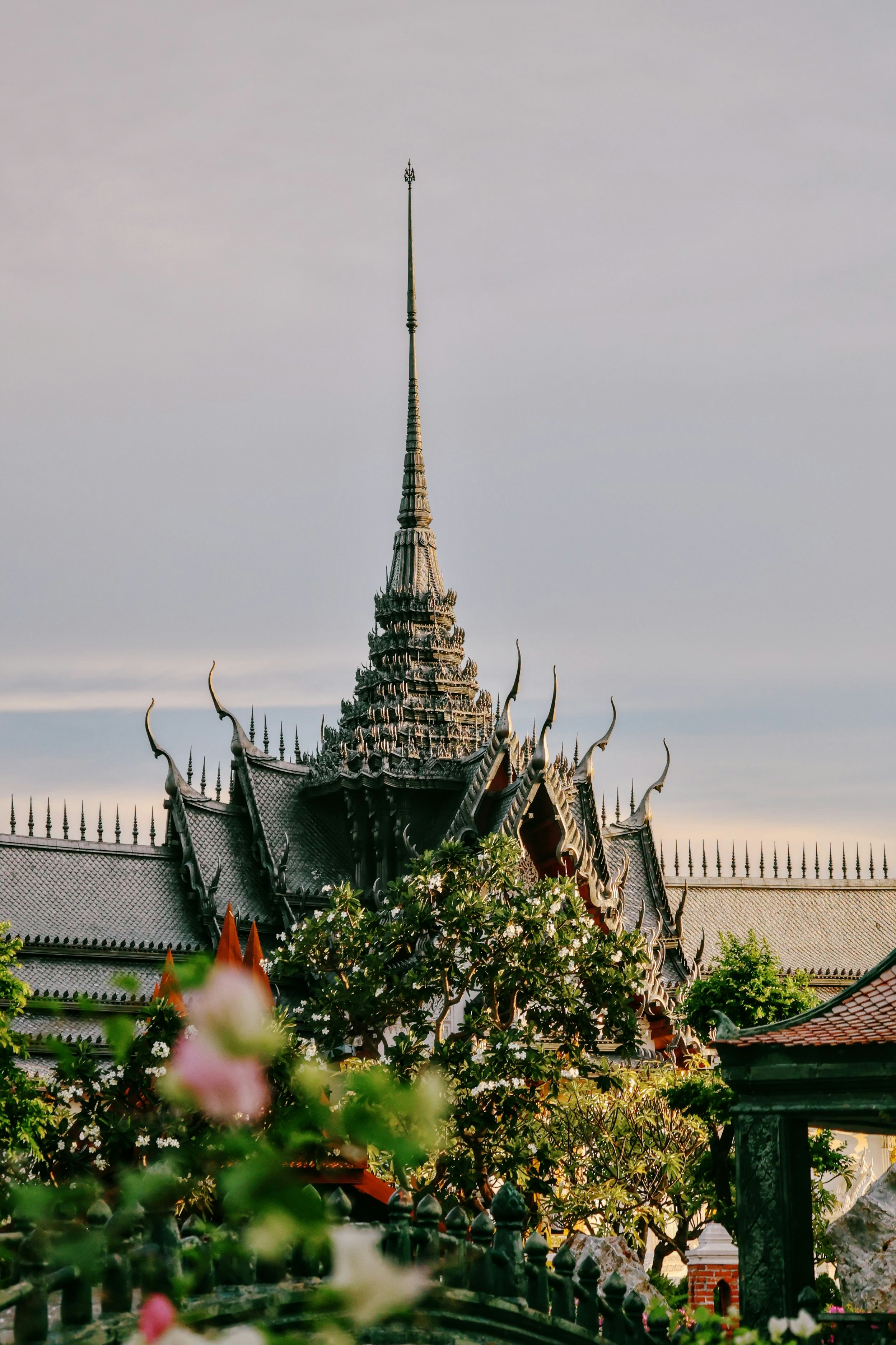 Ornate temple roof with flowering trees in foreground
