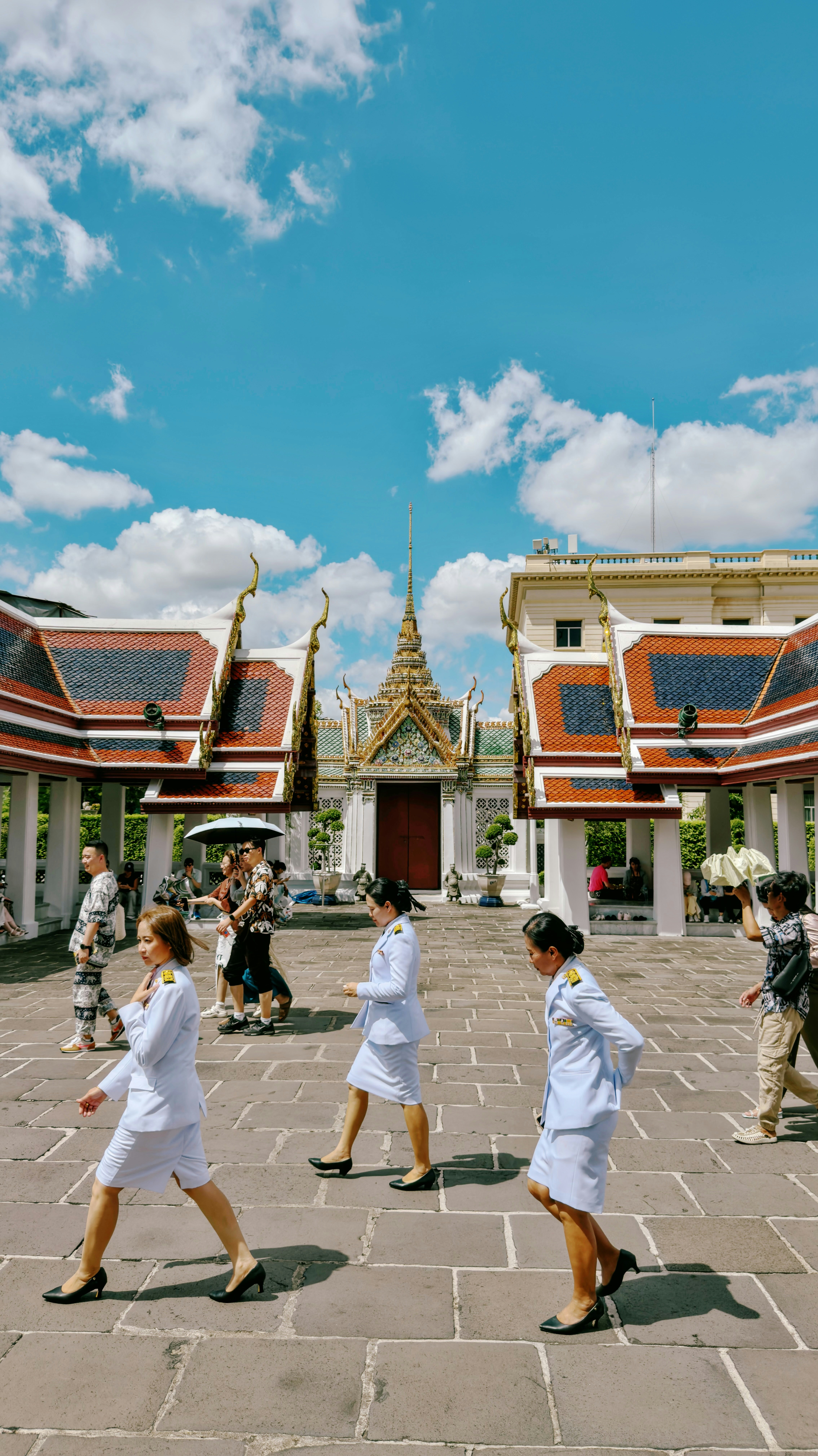 March of White Uniforms Across a Thai Temple Courtyard