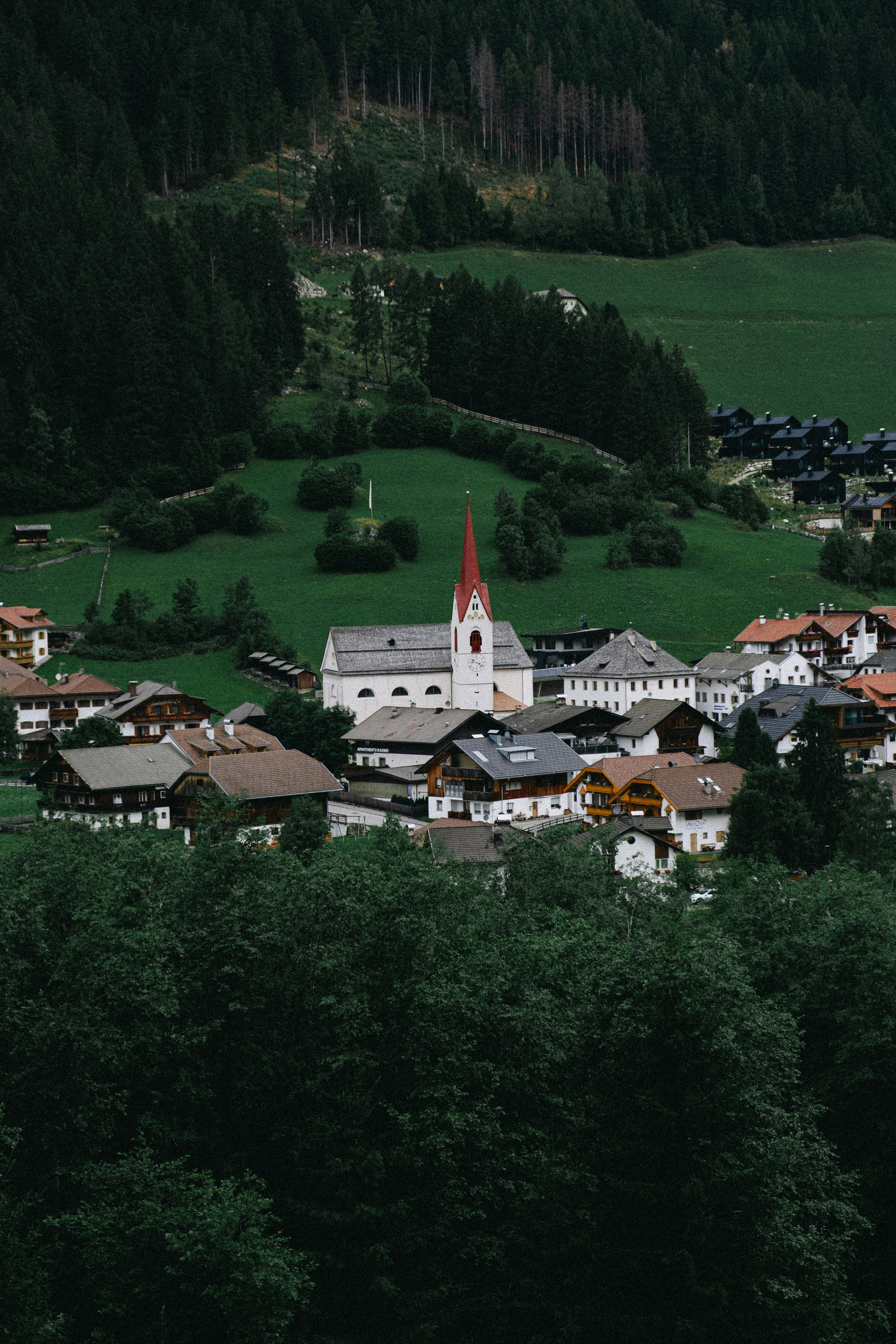 Crimson Spire Anchoring a Verdant Alpine Village