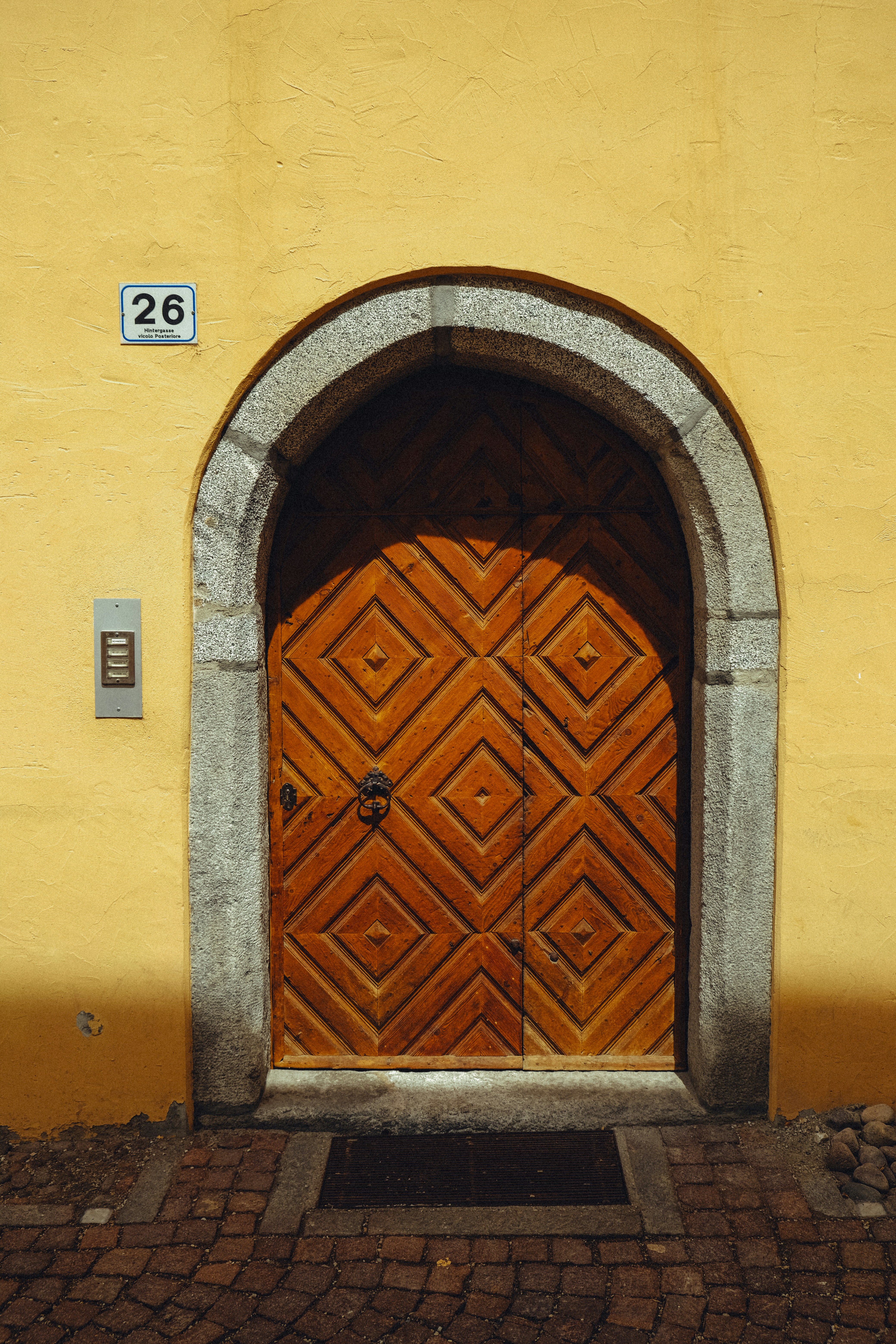 Diamond-Pattern Door Set in a Sunlit Yellow Archway