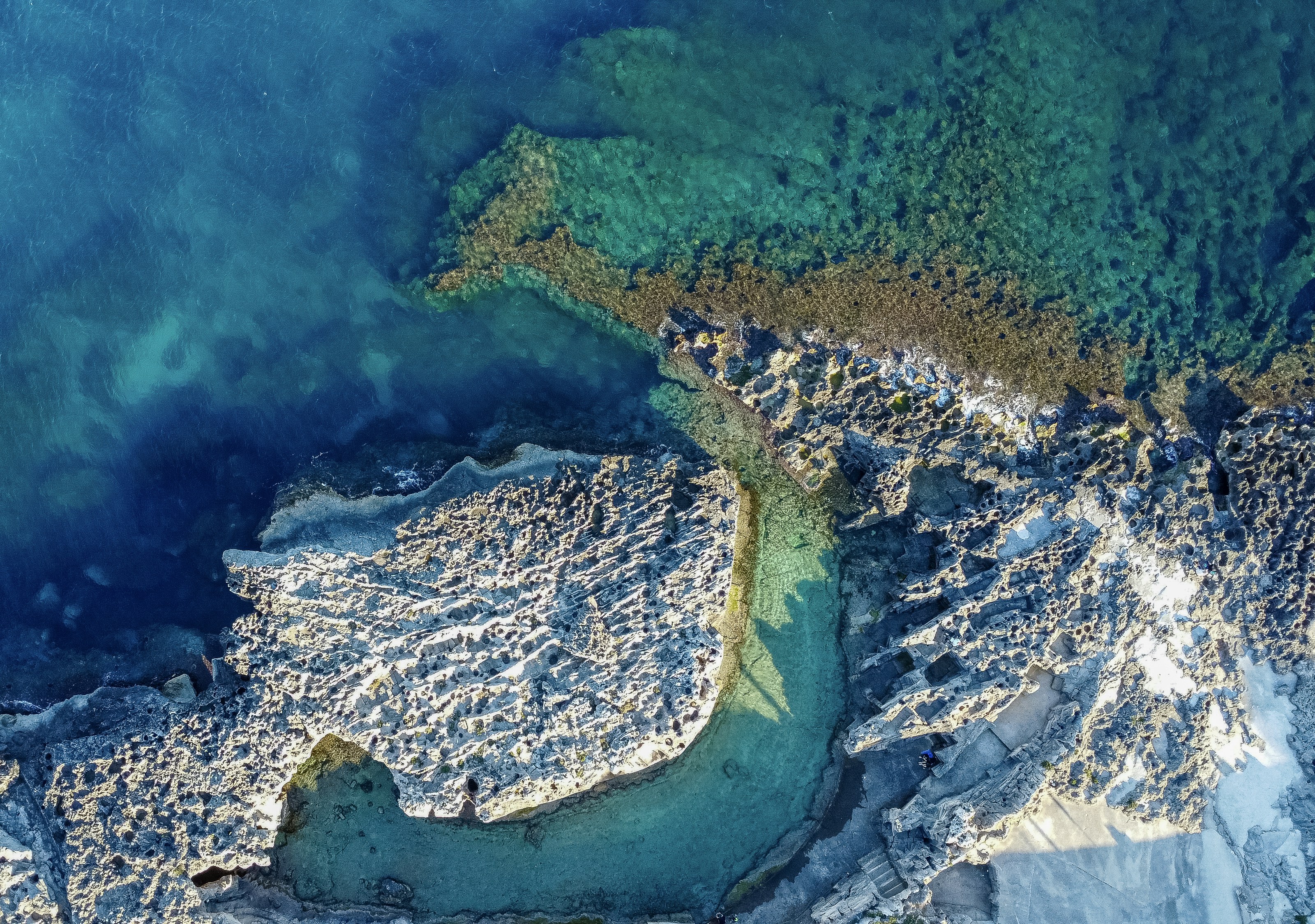 DJI_0015 | Aerial view of rocky coastline and clear blue ocean.