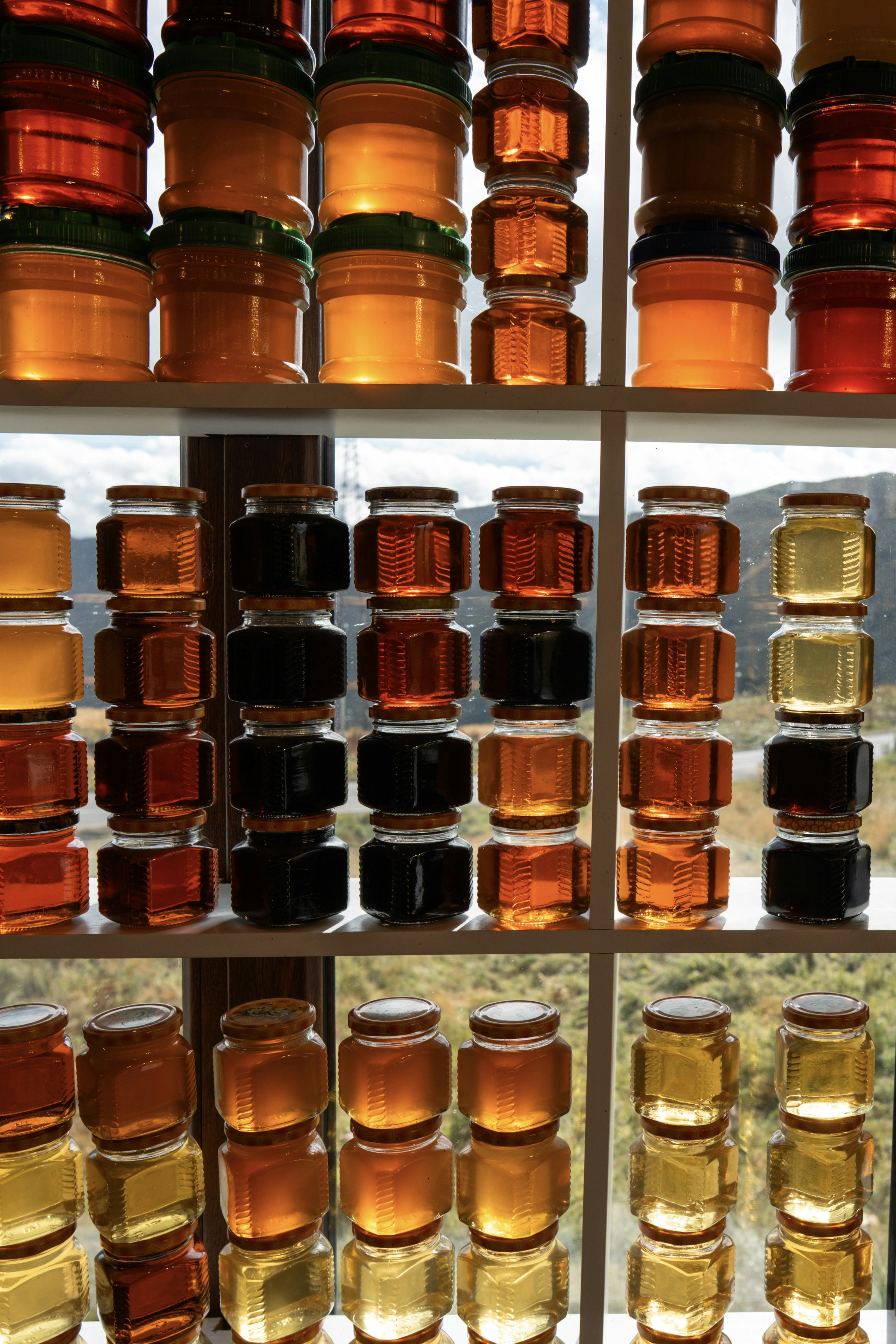 Jars of golden honey stacked on shelves