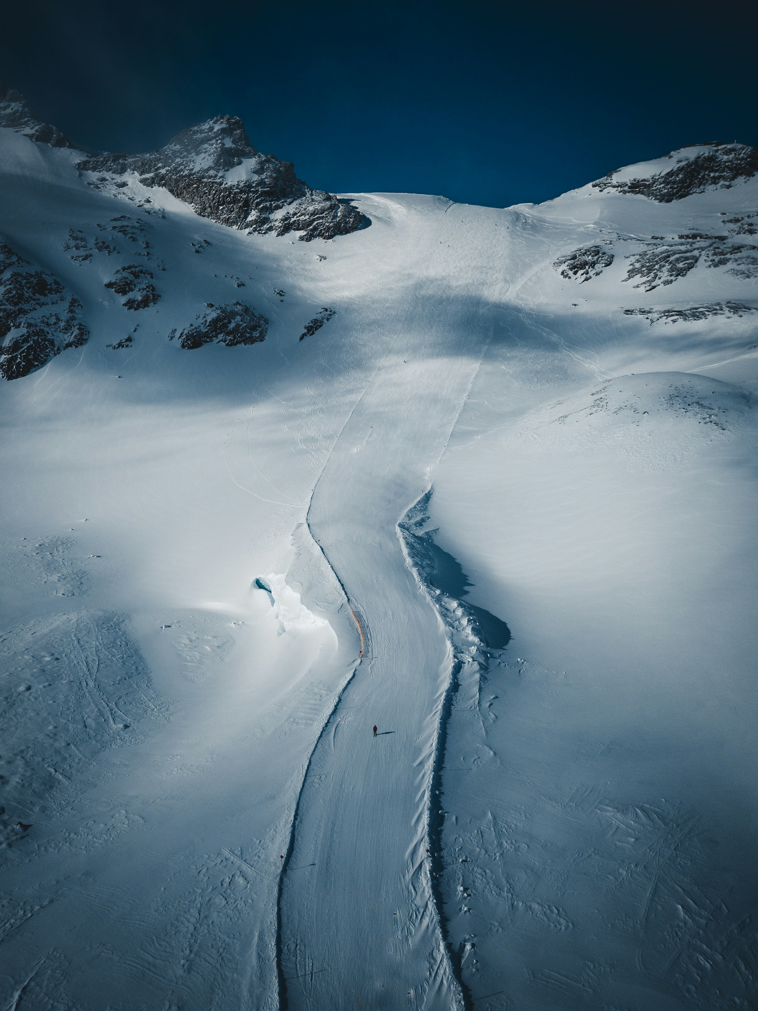Hintertux Glacier in Austria, Slope with one ski driver | A lone skier descends a vast, snow-covered mountain slope.