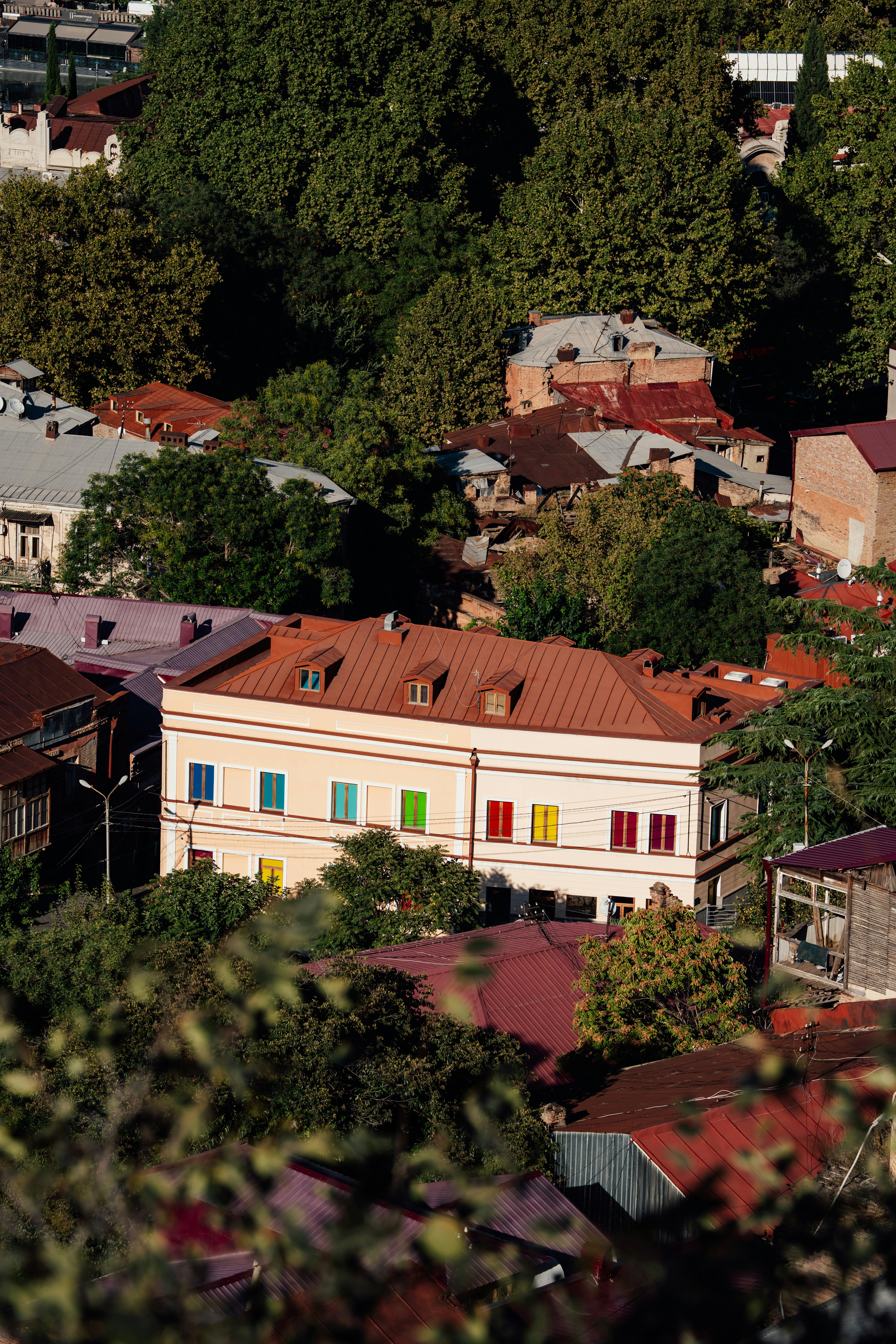 Rainbow-Windowed Rowhouse on a Sunlit Hillside Street