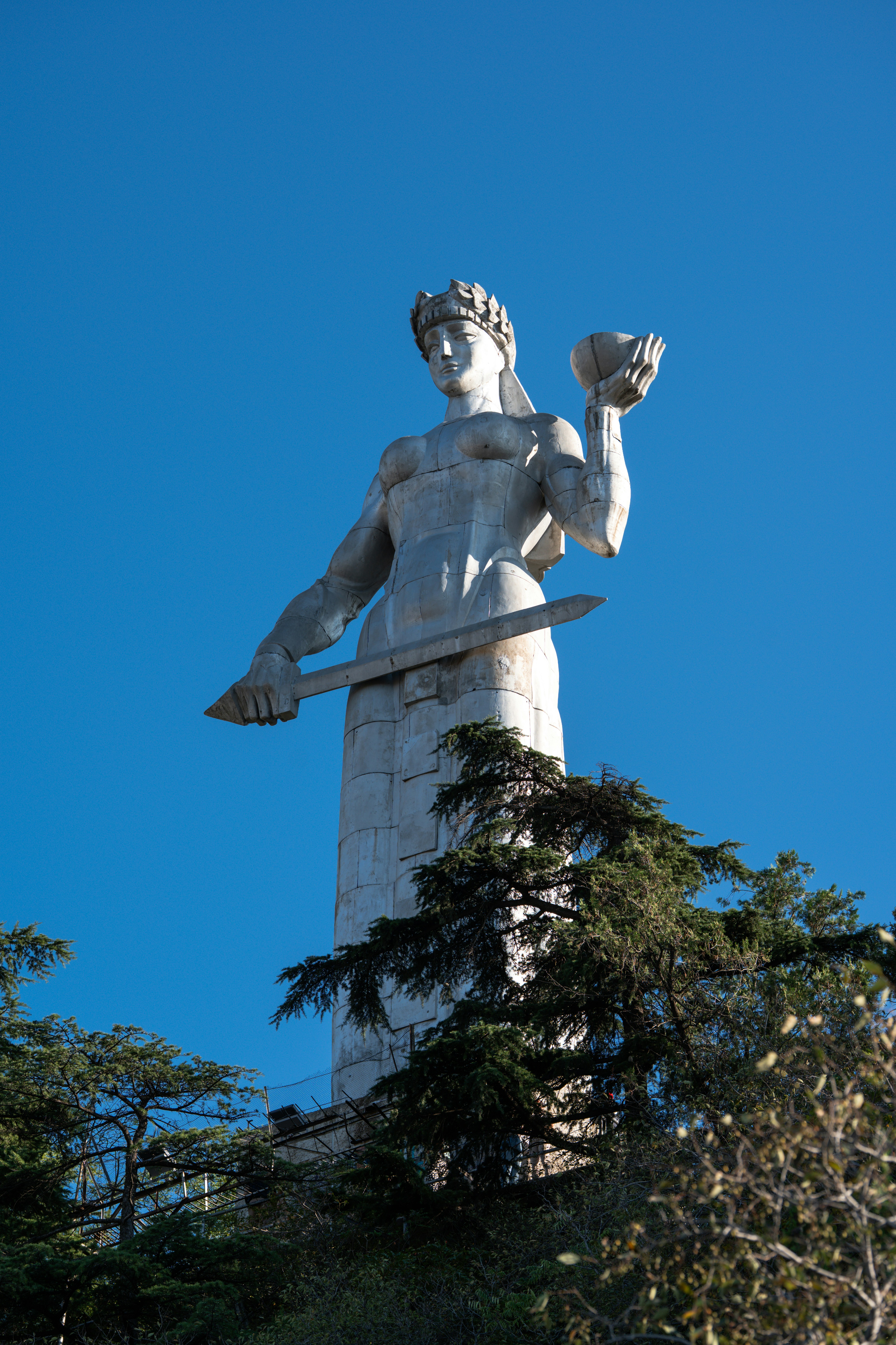 Monumental statue of a woman holding a sword and bowl.