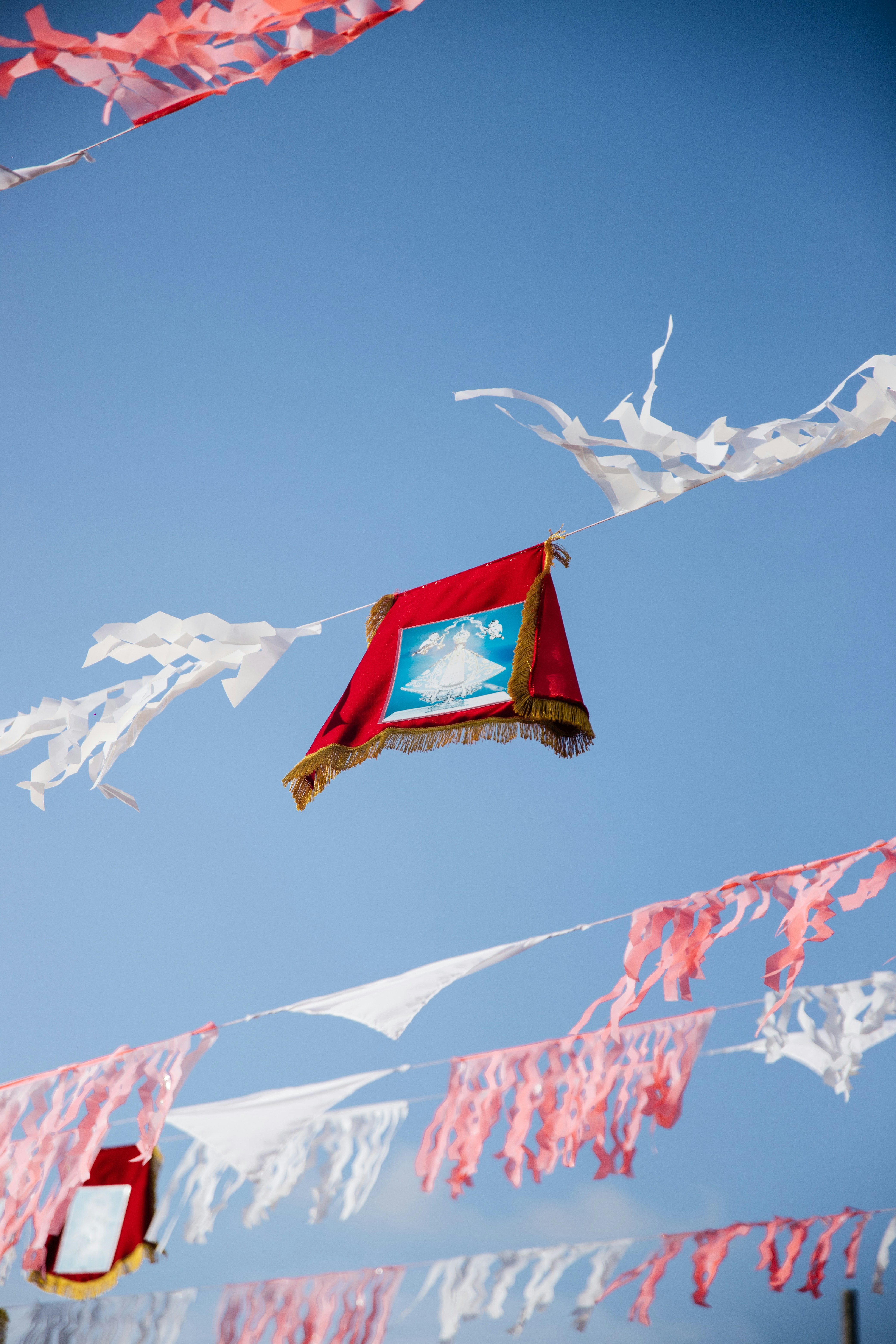 Crimson Pennant with Mountain Emblem Adrift Beneath a Clear Blue Sky