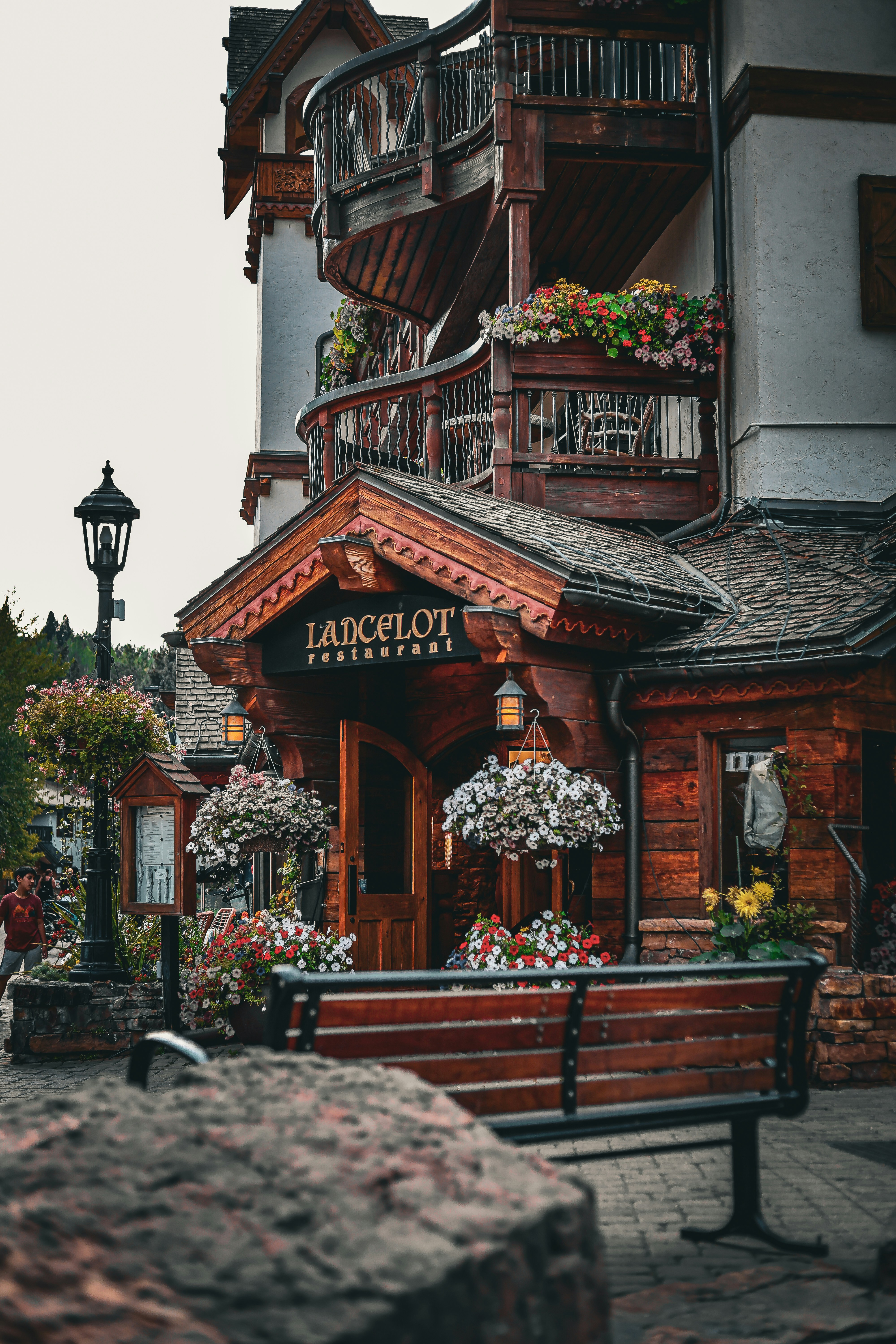 Quaint restaurant entrance adorned with vibrant flowers and rustic wooden architecture, inviting patrons to enjoy a delightful dining experience.