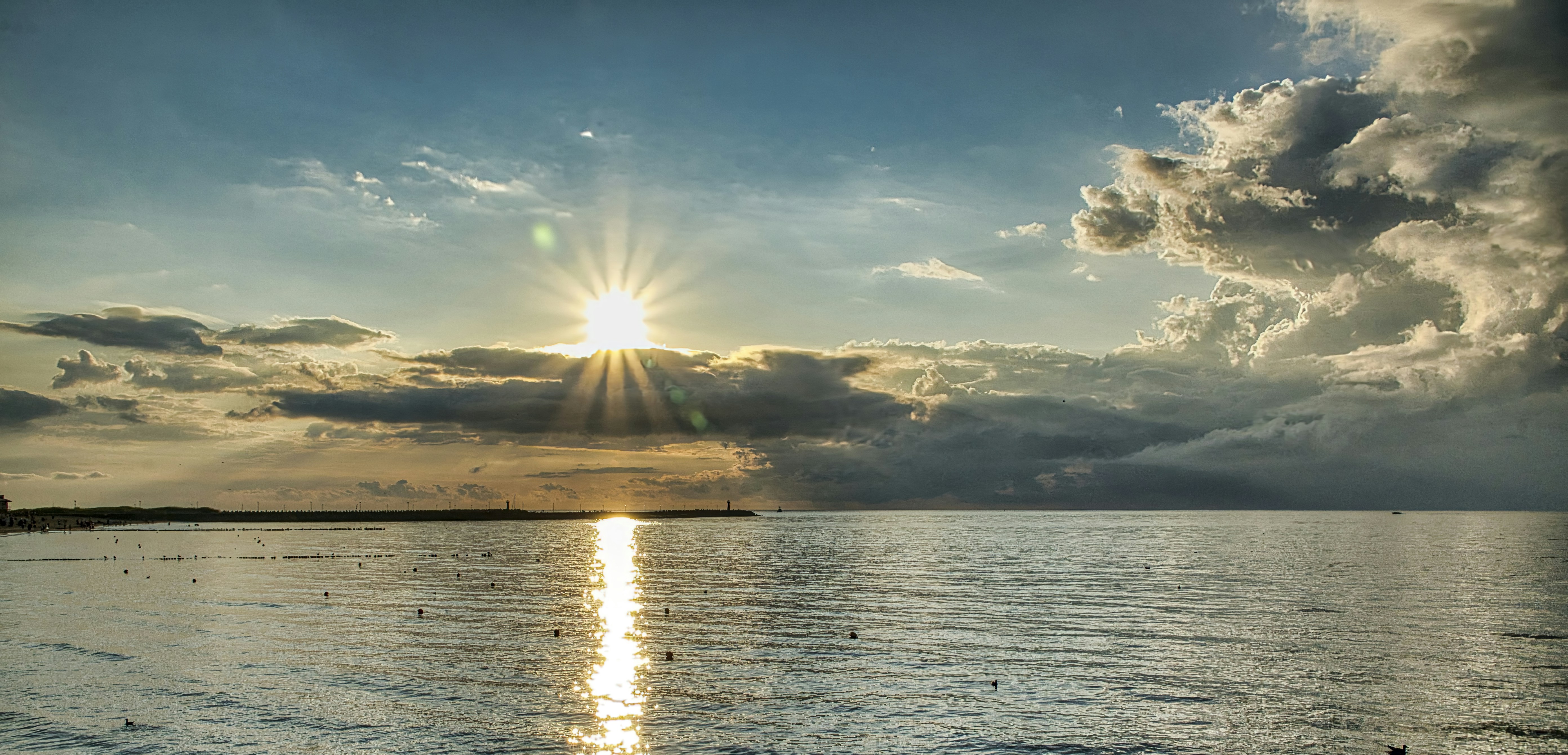 Sun setting over a calm ocean with dramatic clouds photo – Free Image ...
