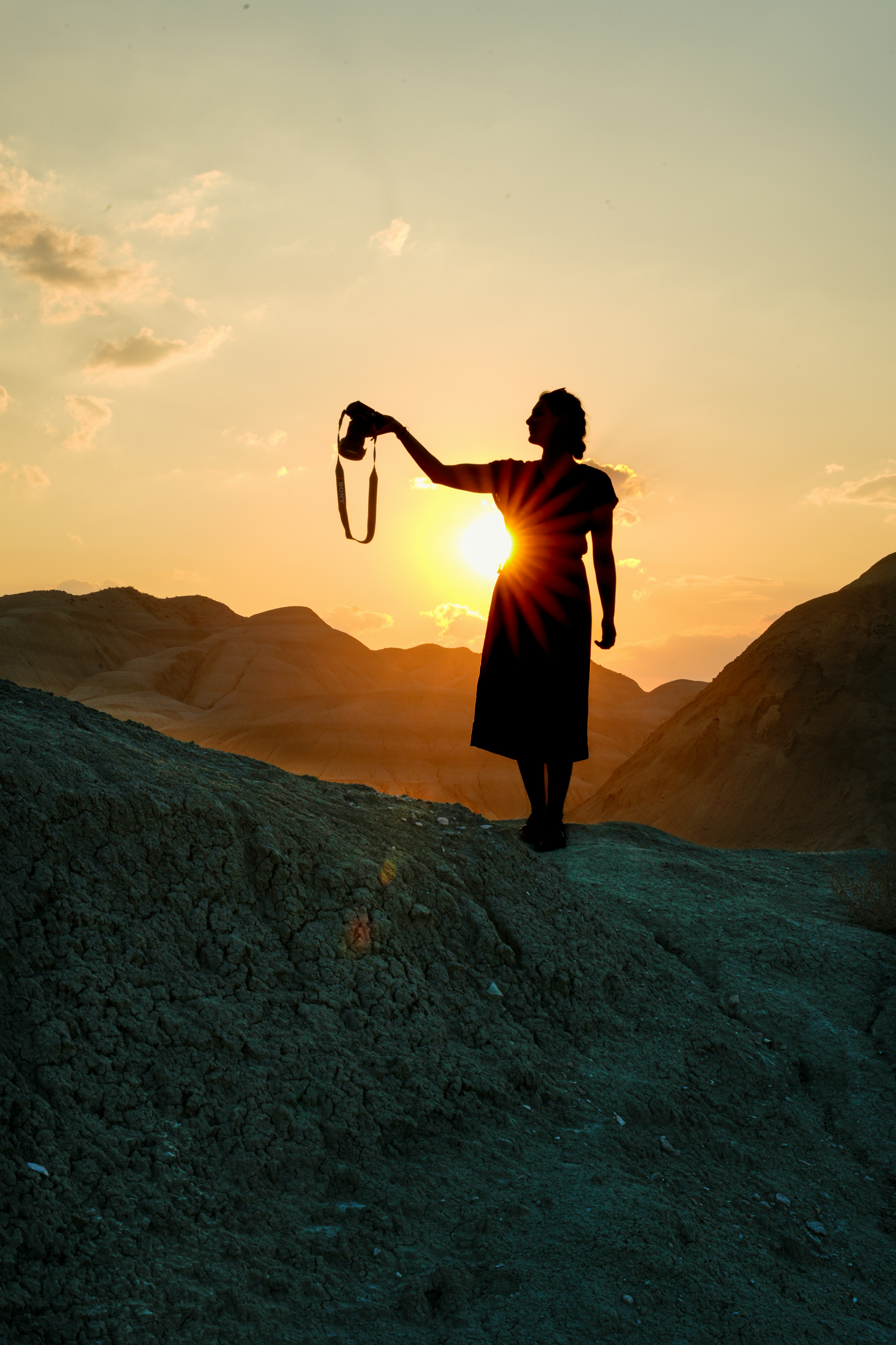 Sunburst Summit: A lone silhouette lifts a camera at golden hour