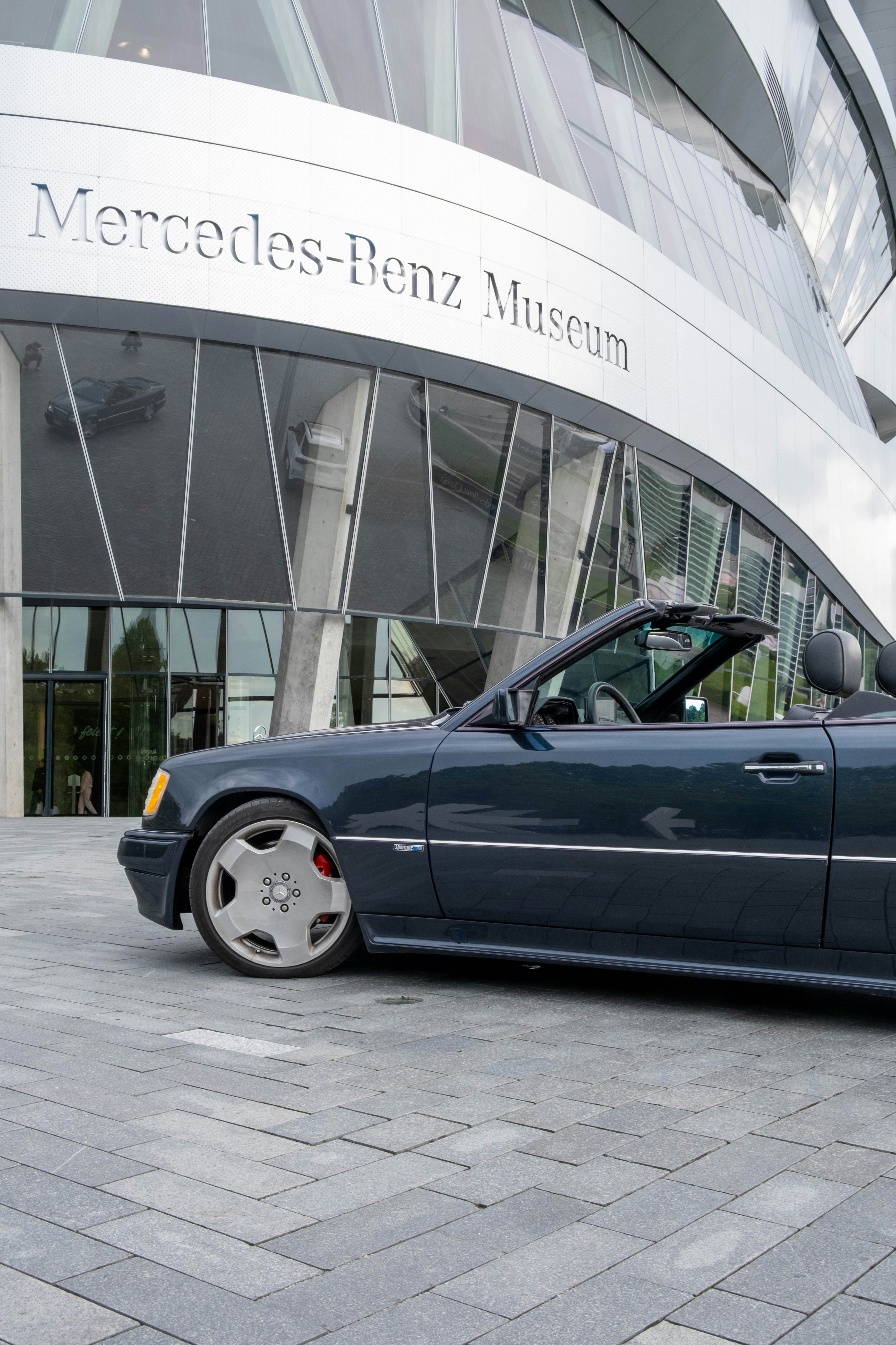 Blue Convertible at the Mercedes-Benz Museum’s Curved Glass Facade
