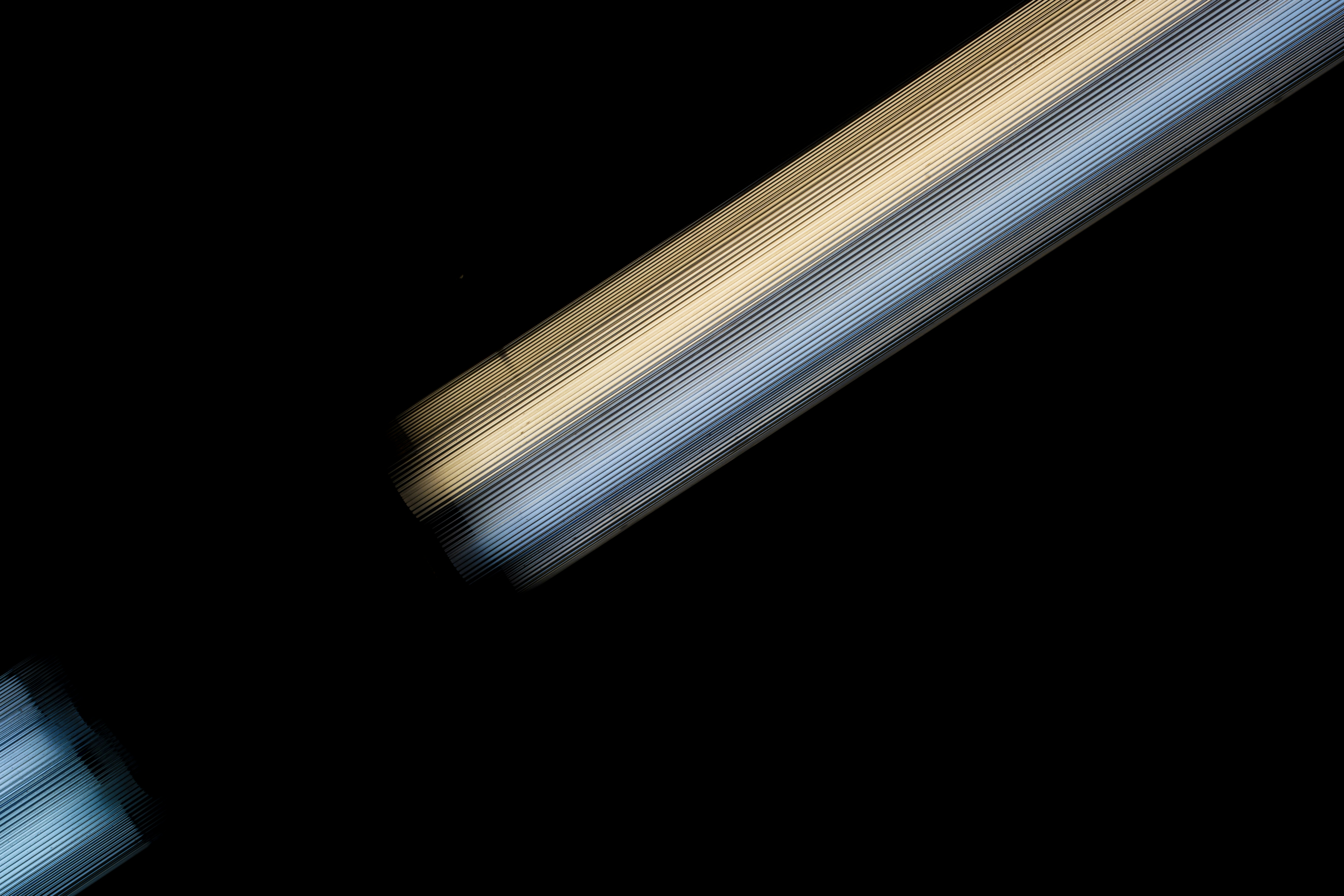 Diagonal light streaks against black background