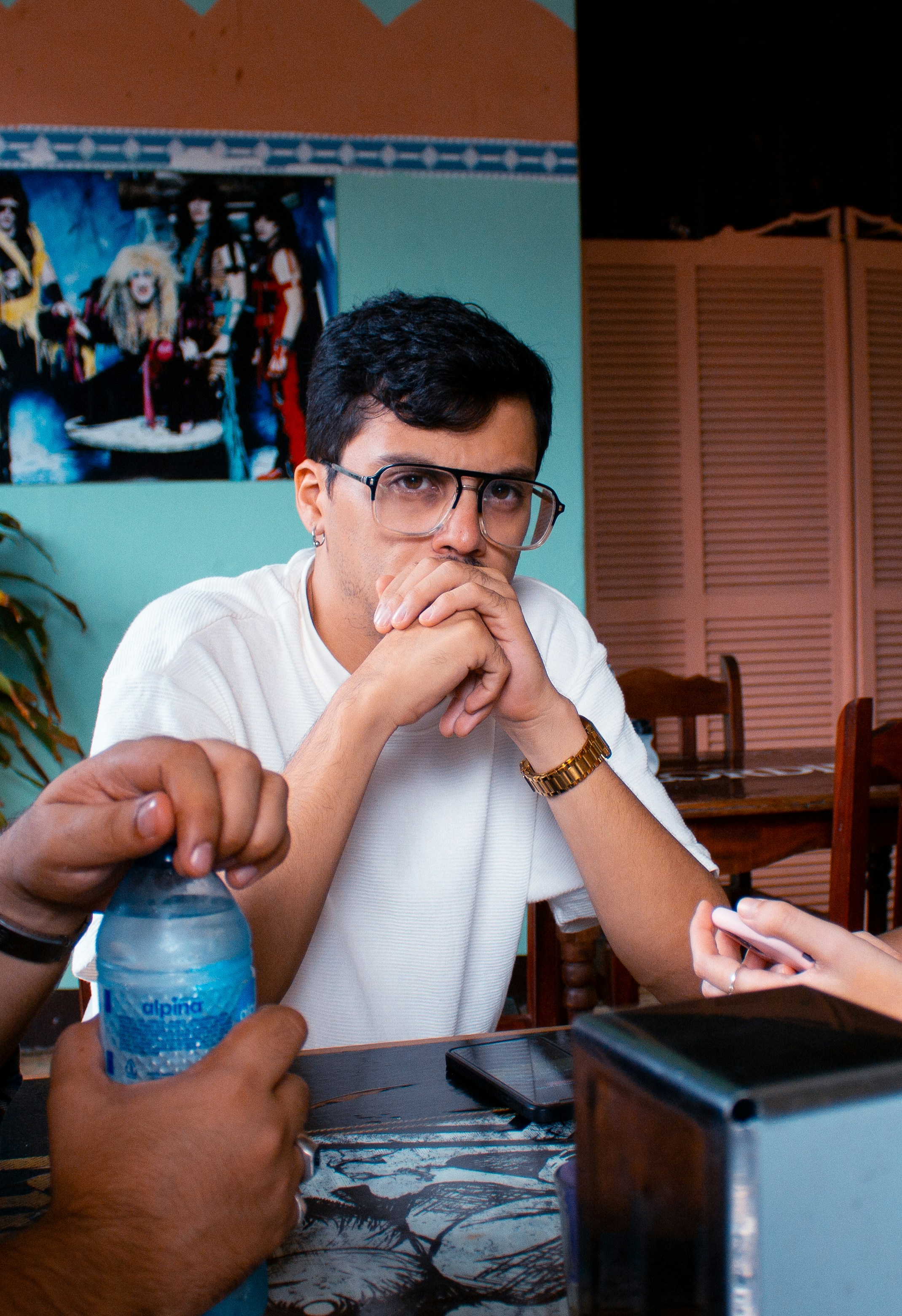 Gaze Beneath Glasses: A Quiet Portrait at a Teal-Walled Café
