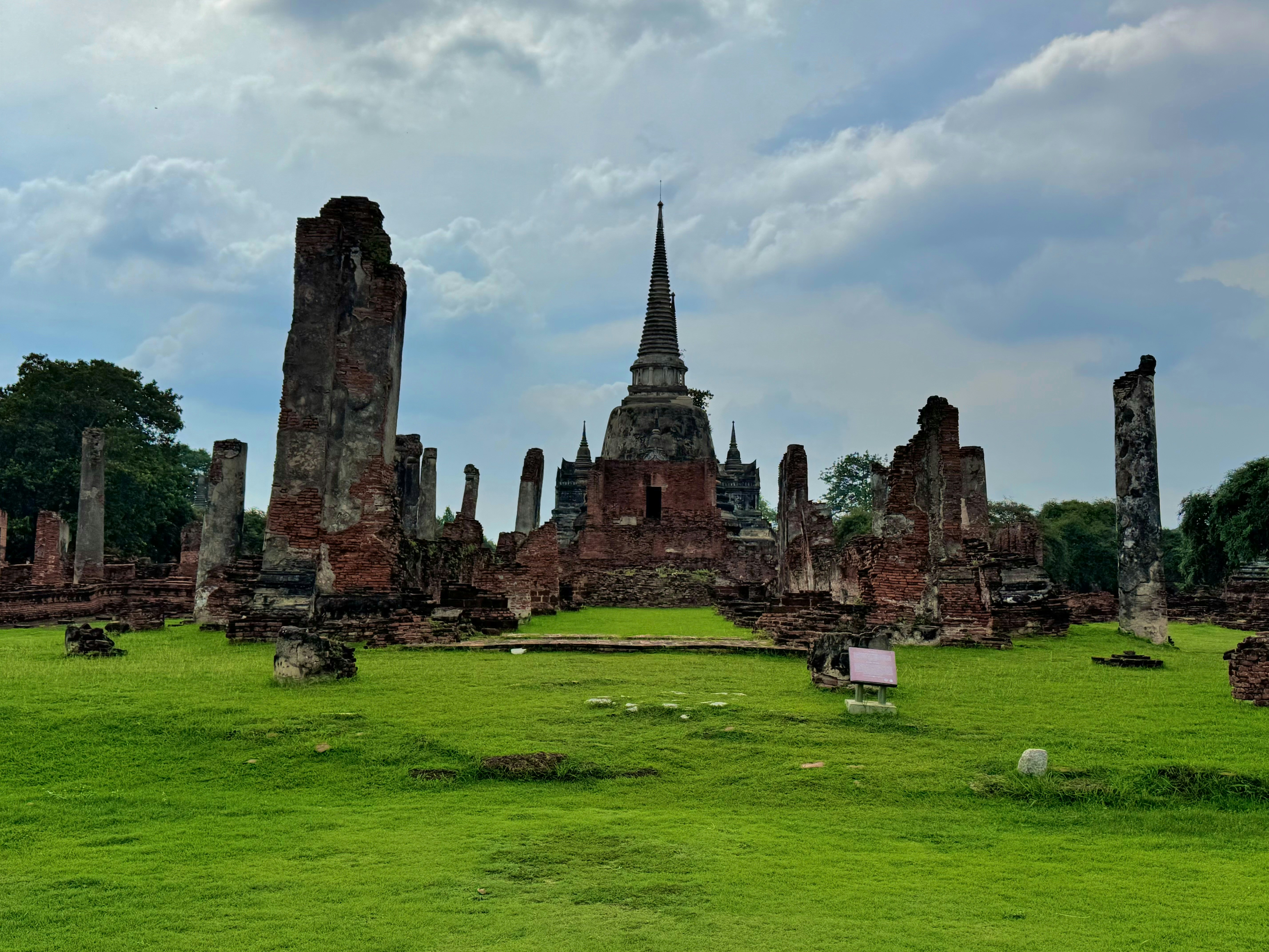 Ancient ruins of a temple complex with green grass.