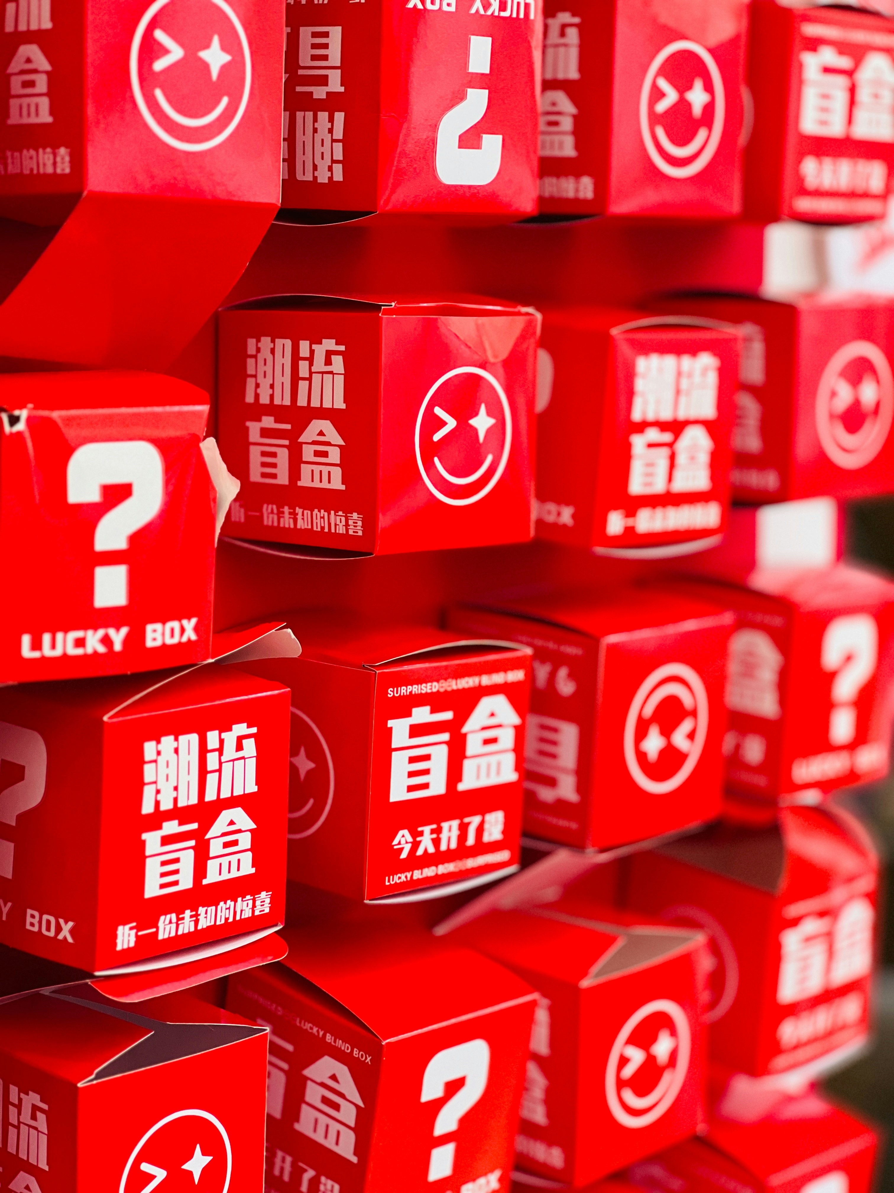 A vibrant display of red boxes featuring playful graphics and intriguing symbols, inviting curiosity and interaction.