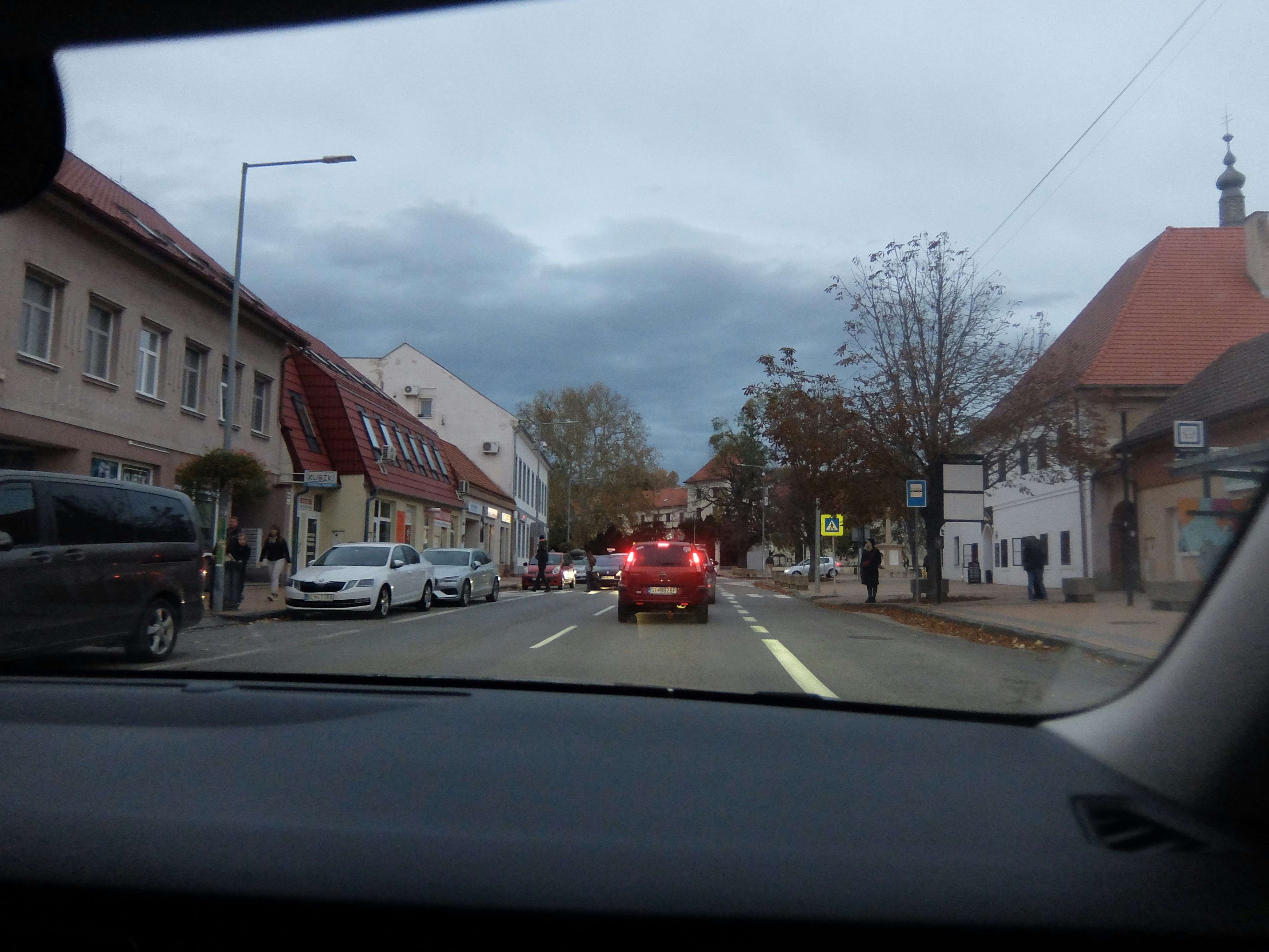 Cars driving down a street in a town.
