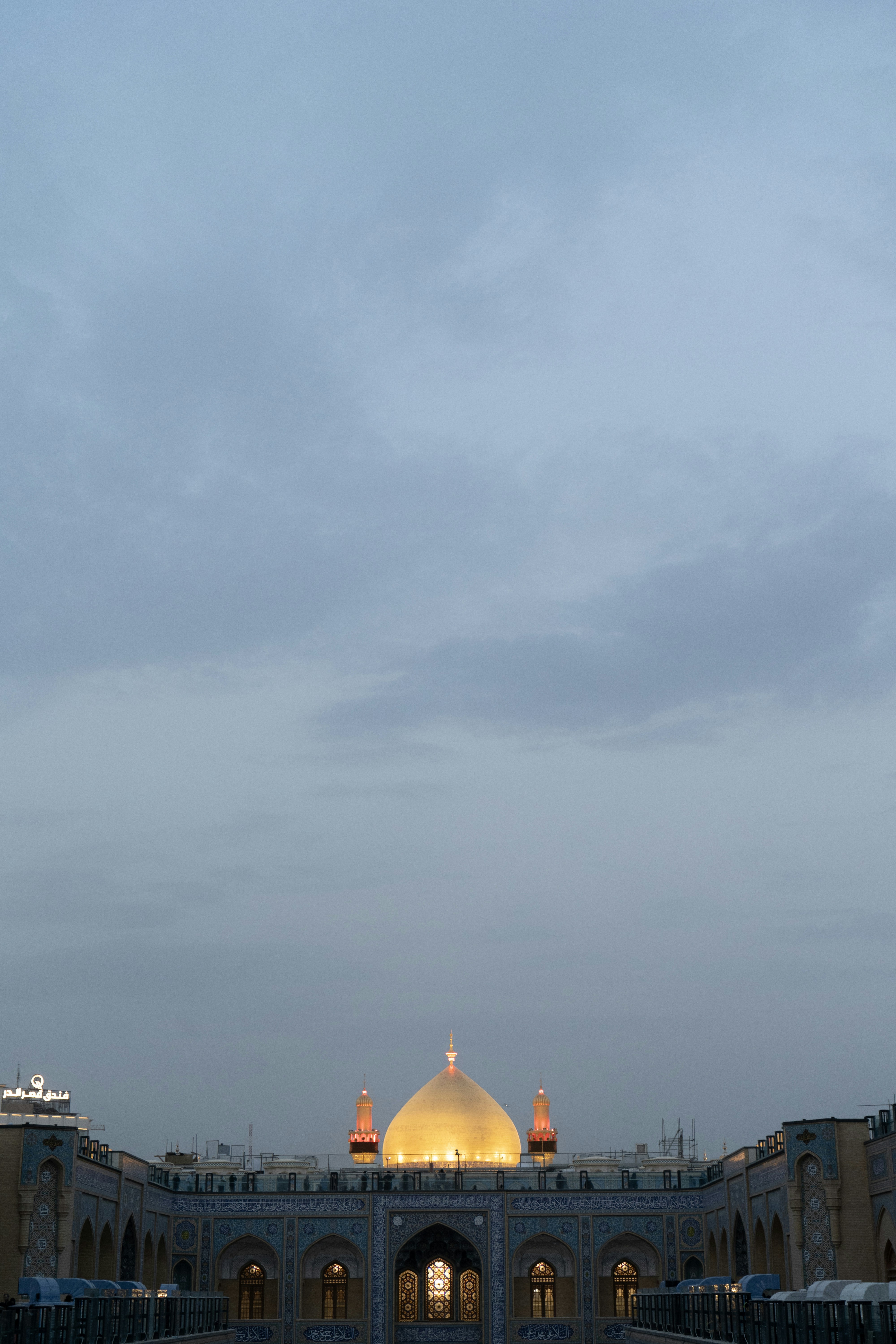 Holy shrine of Imam Ali pbuh, Najaf arbaeen | Golden dome of a mosque under a cloudy sky.