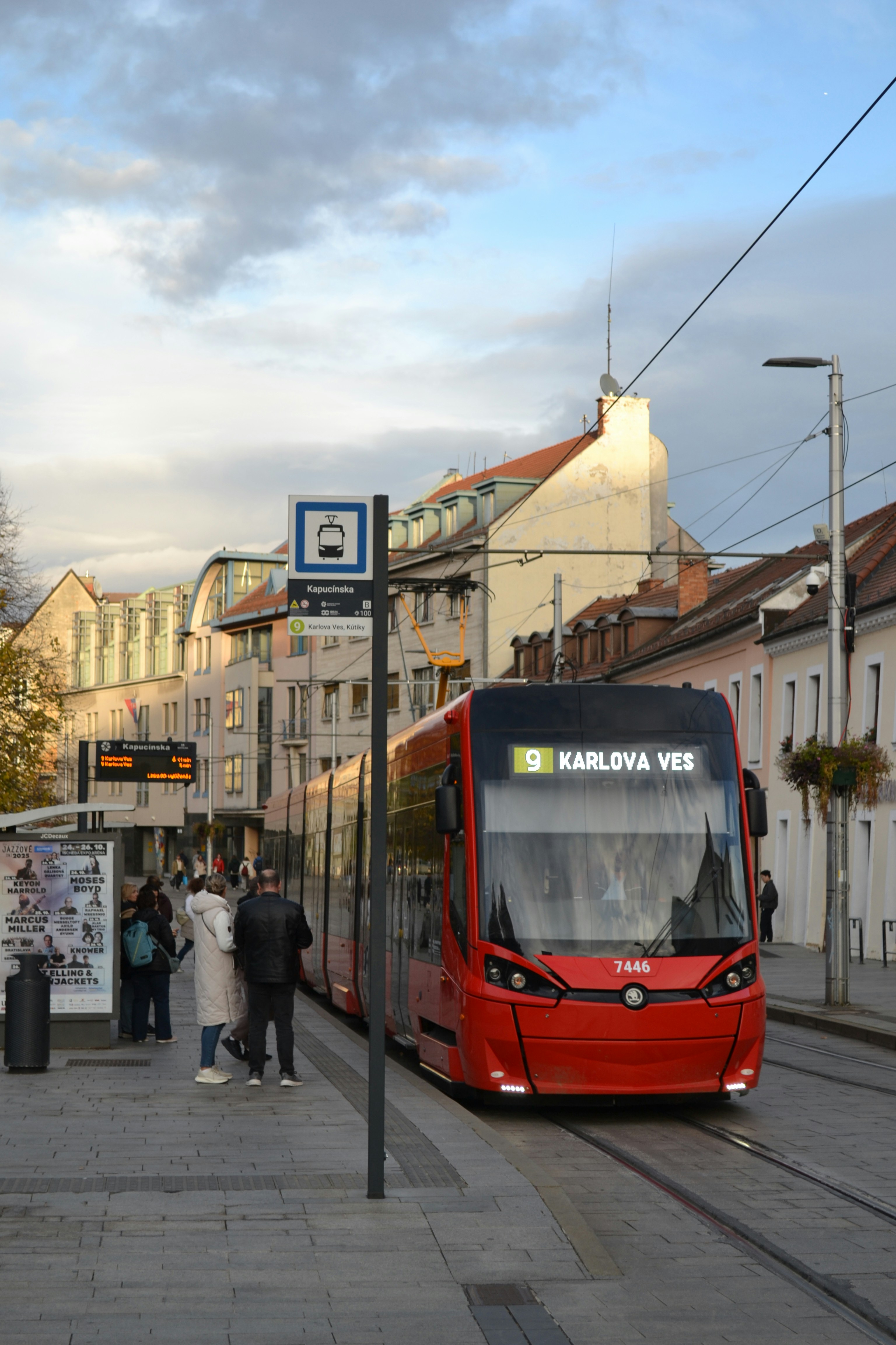 Crimson Commuter: a red tram threads through a sunlit town