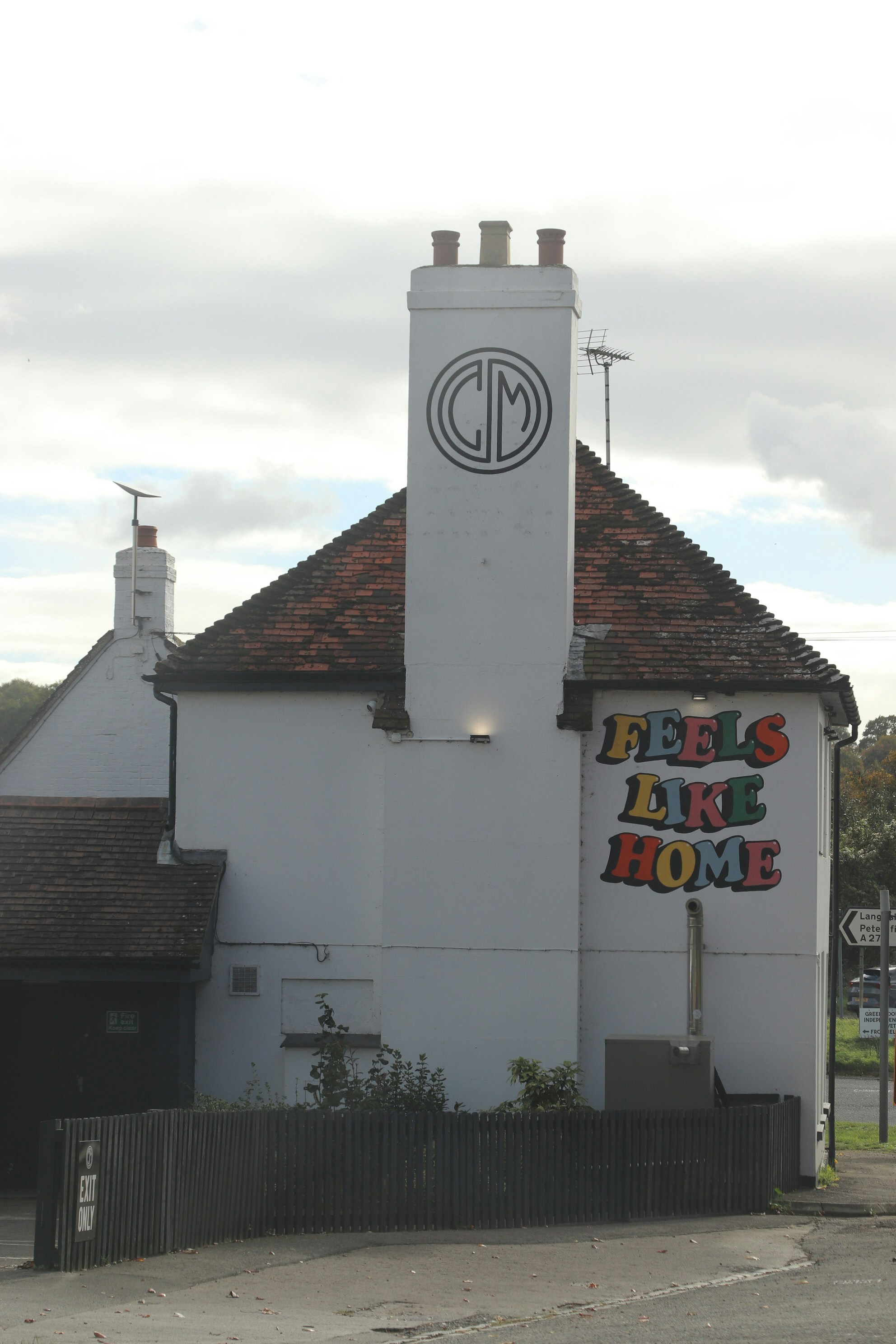 White building with "feels like home" graffiti