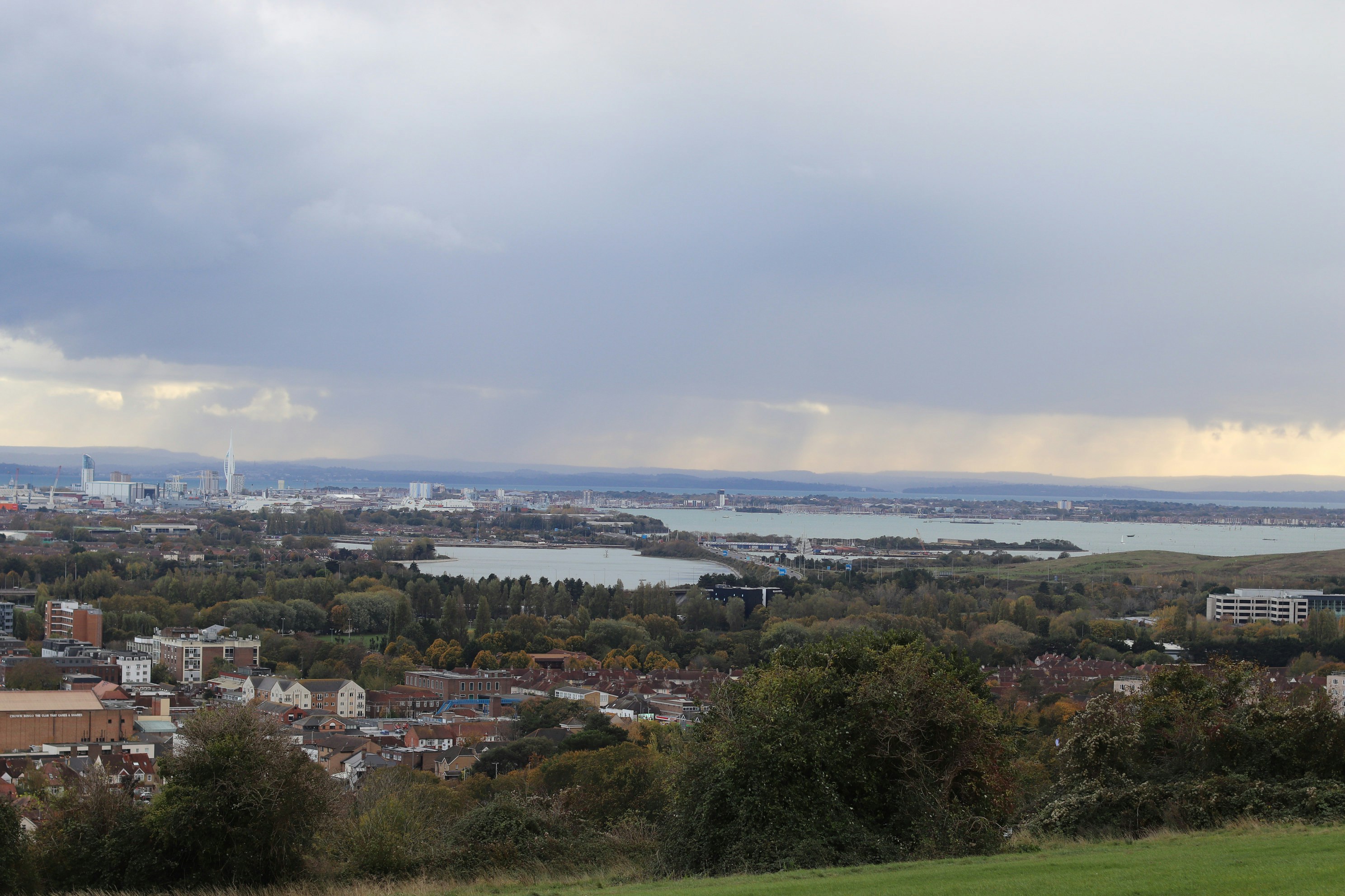 Overcast sky above a coastal town and harbor.
