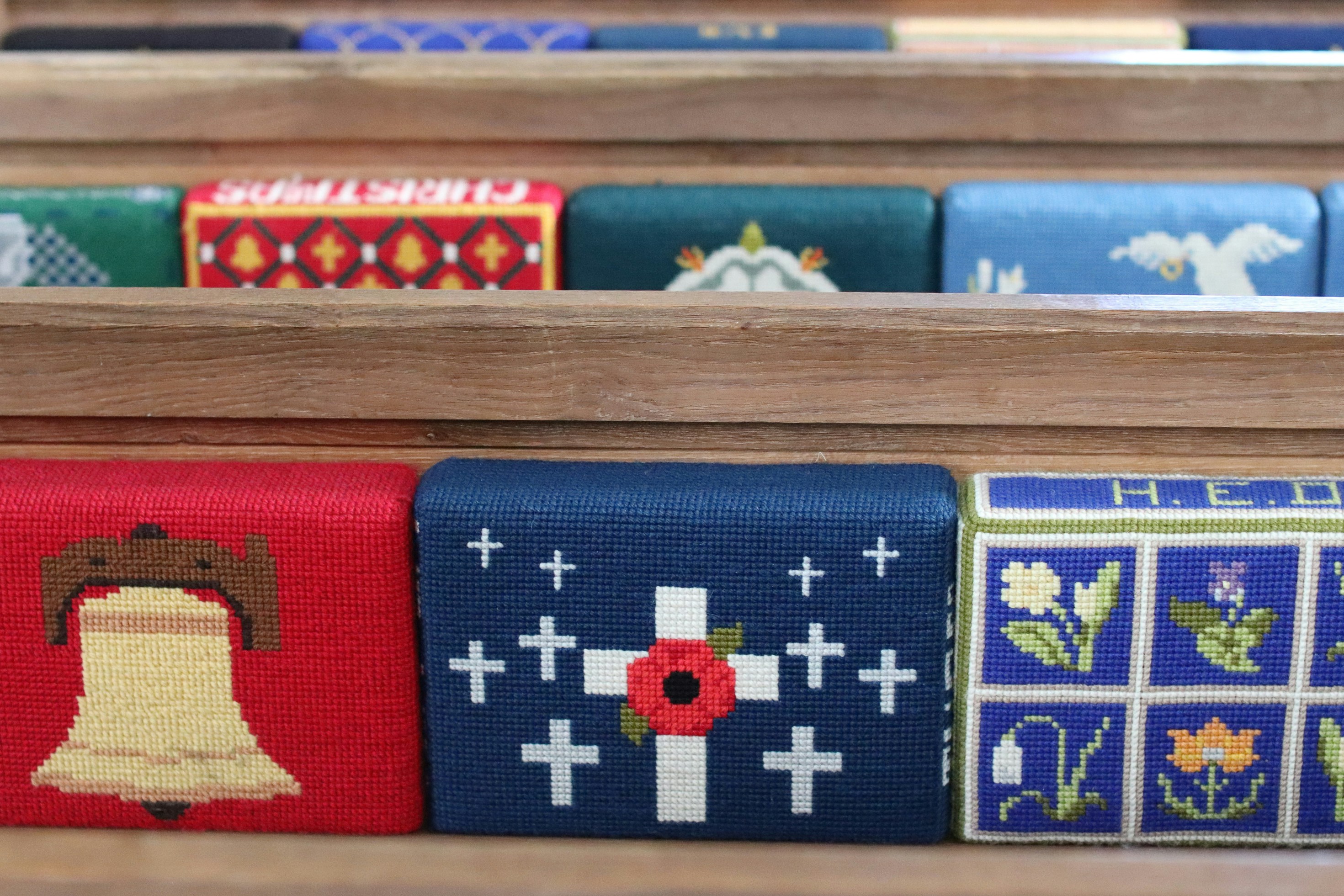 Row of decorative embroidered panels with religious and patriotic symbols.