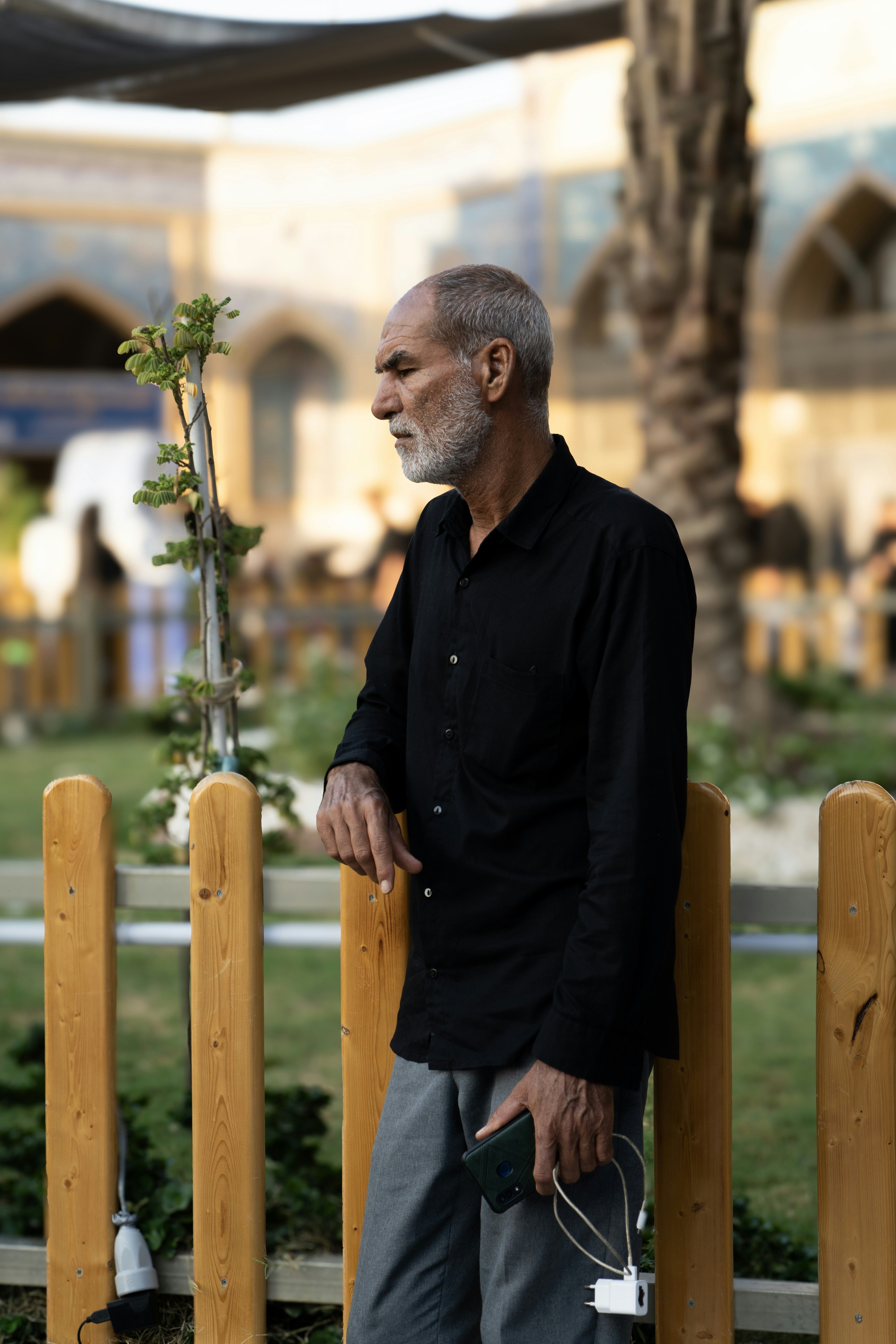 Holy shrine of Imam Ali pbuh, Najaf arbaeen | An elderly man in a black shirt stands outside.