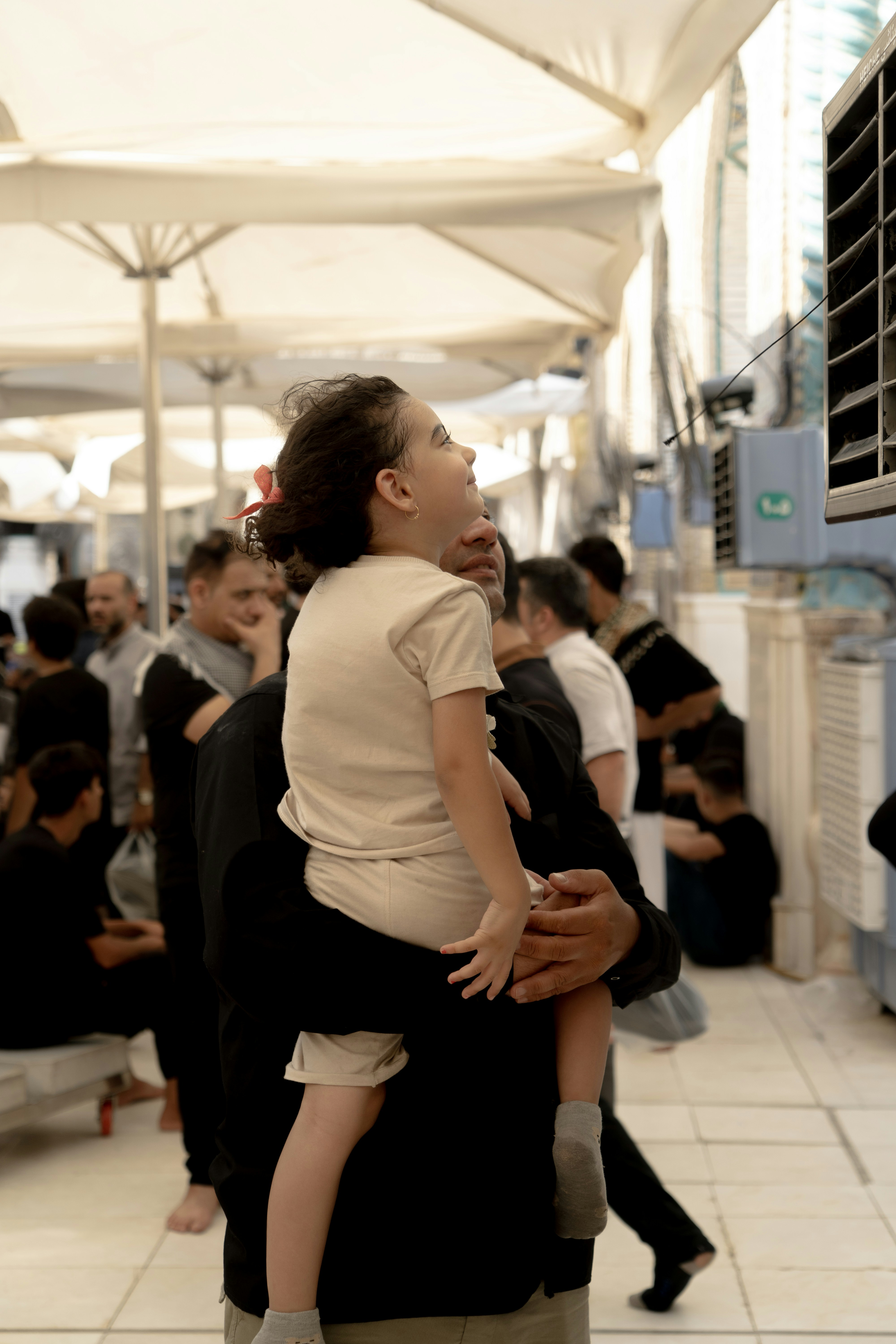 Father carrying a child looking up in a crowd. photo – Free People ...