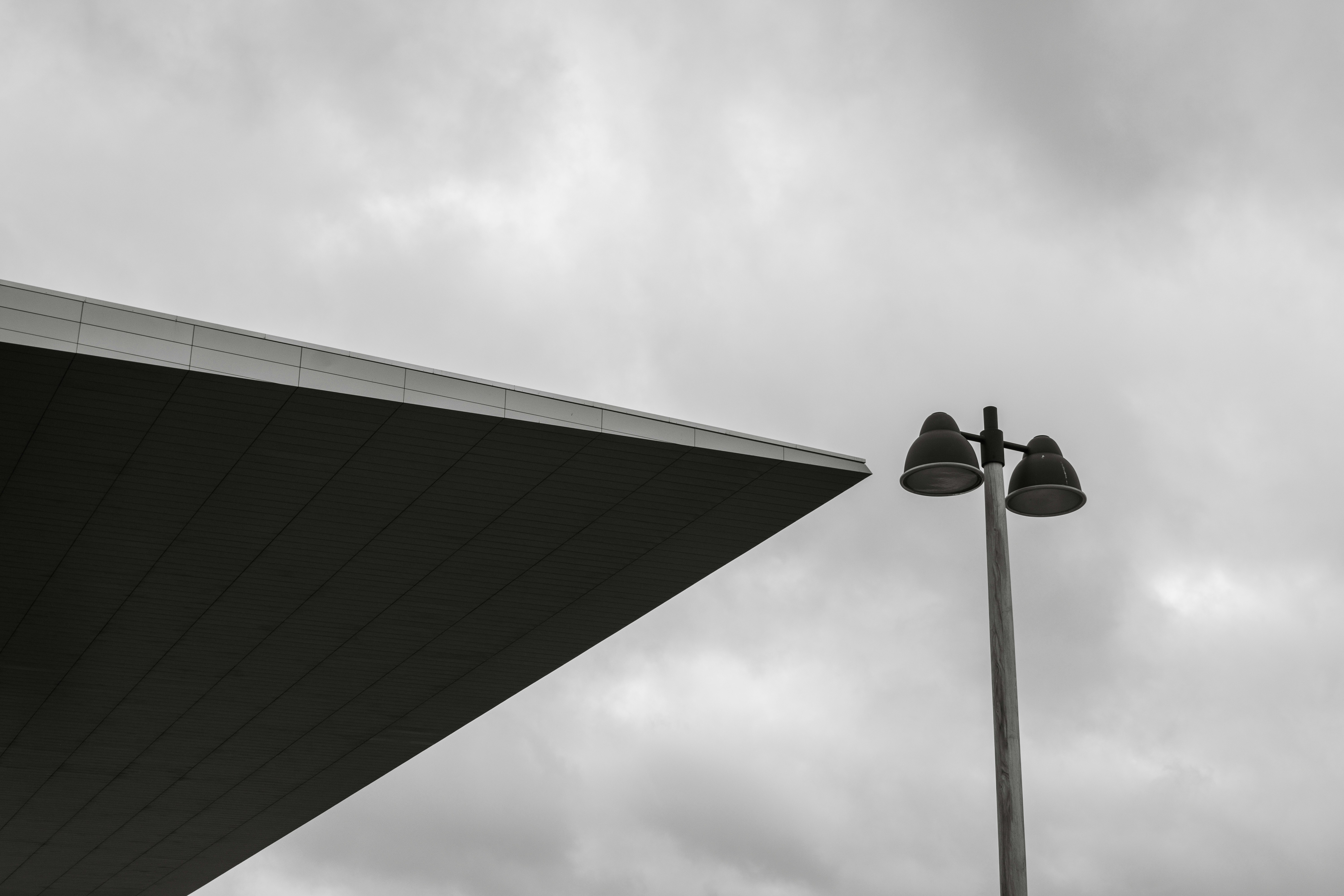 Modern building corner and street lamp against sky